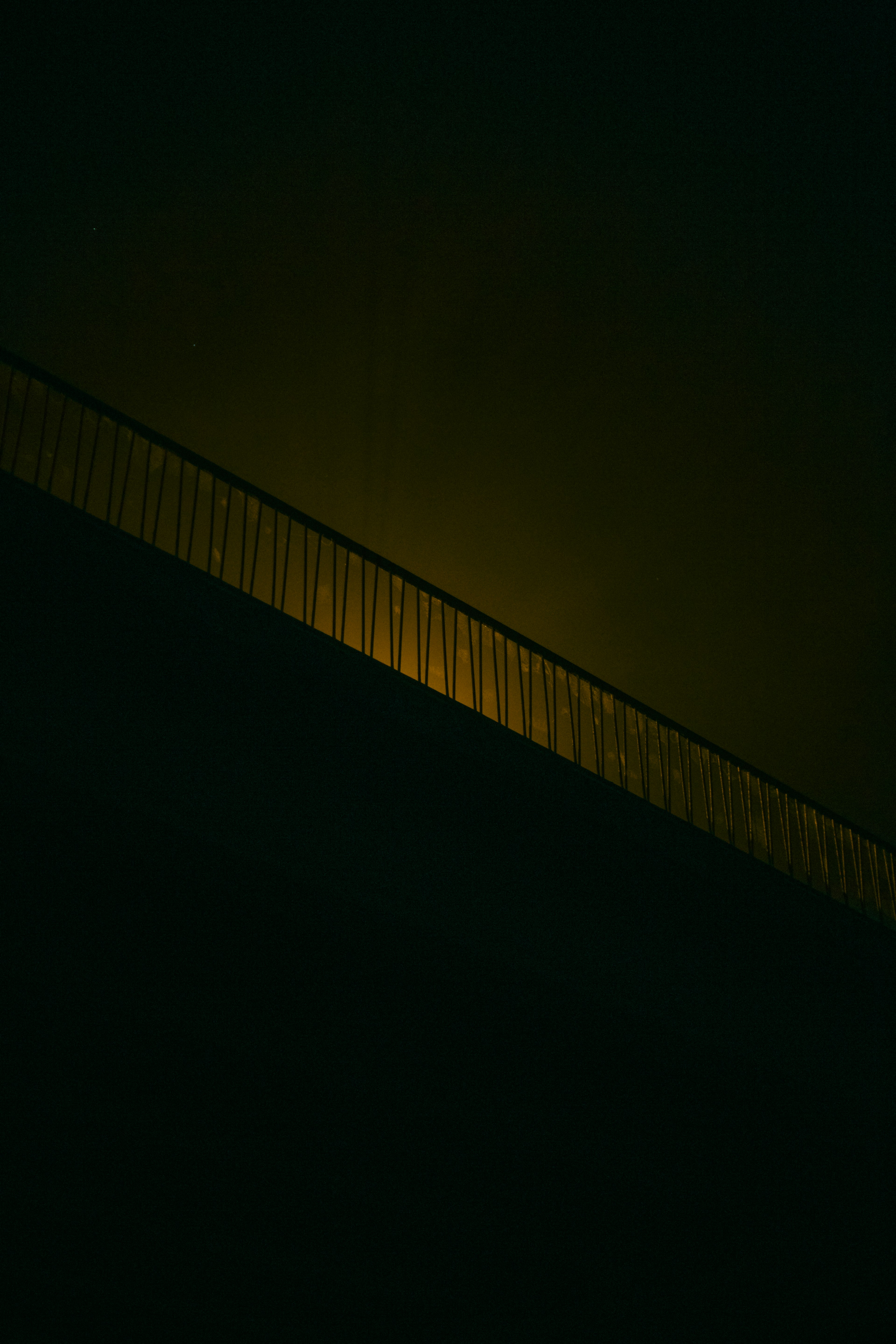 Suspended Line of Quiet: A Moonlit Railing on a Shadowed Slope