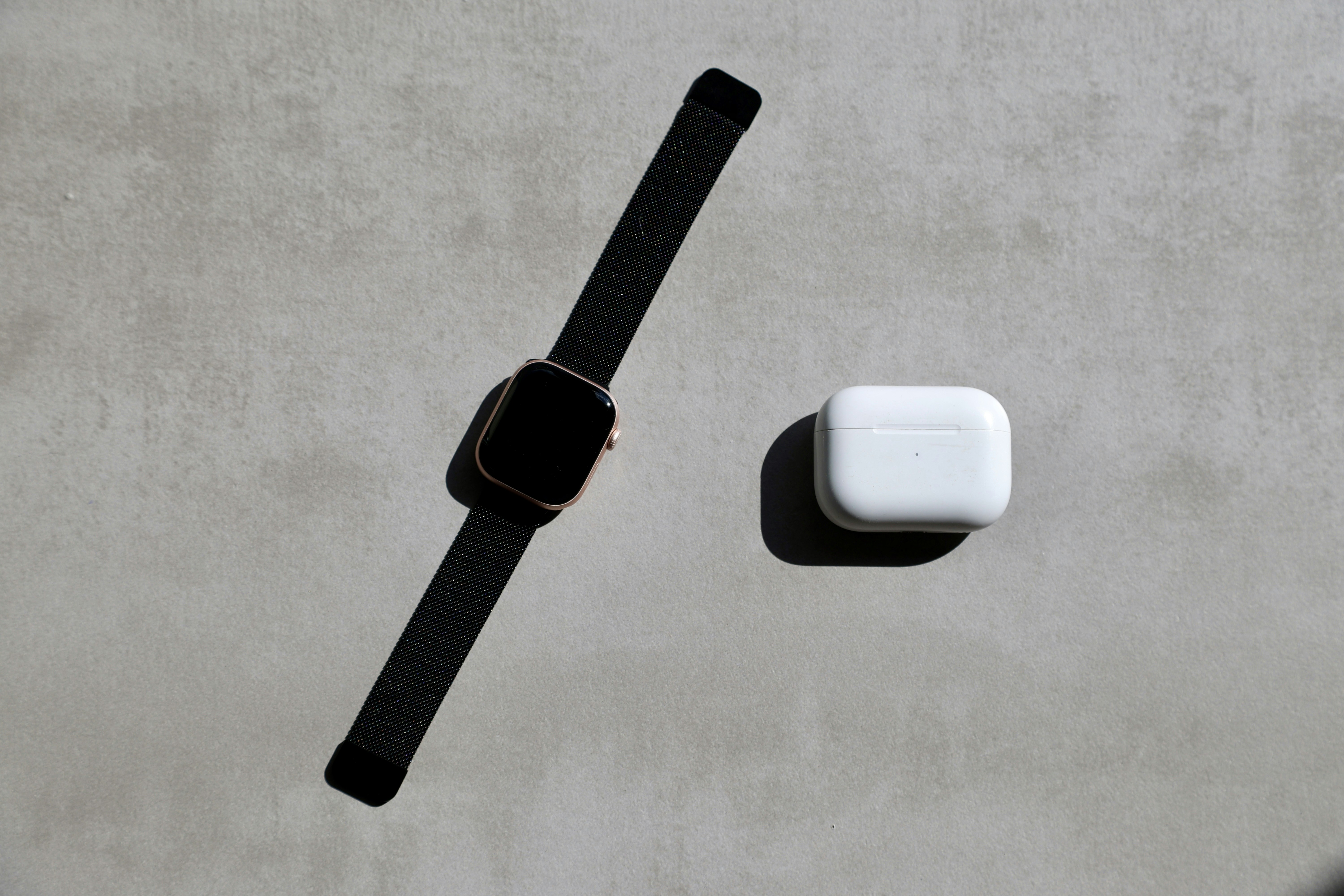 Minimalist Tech Diary: A Smartwatch and Case on a Sunlit Concrete Tile