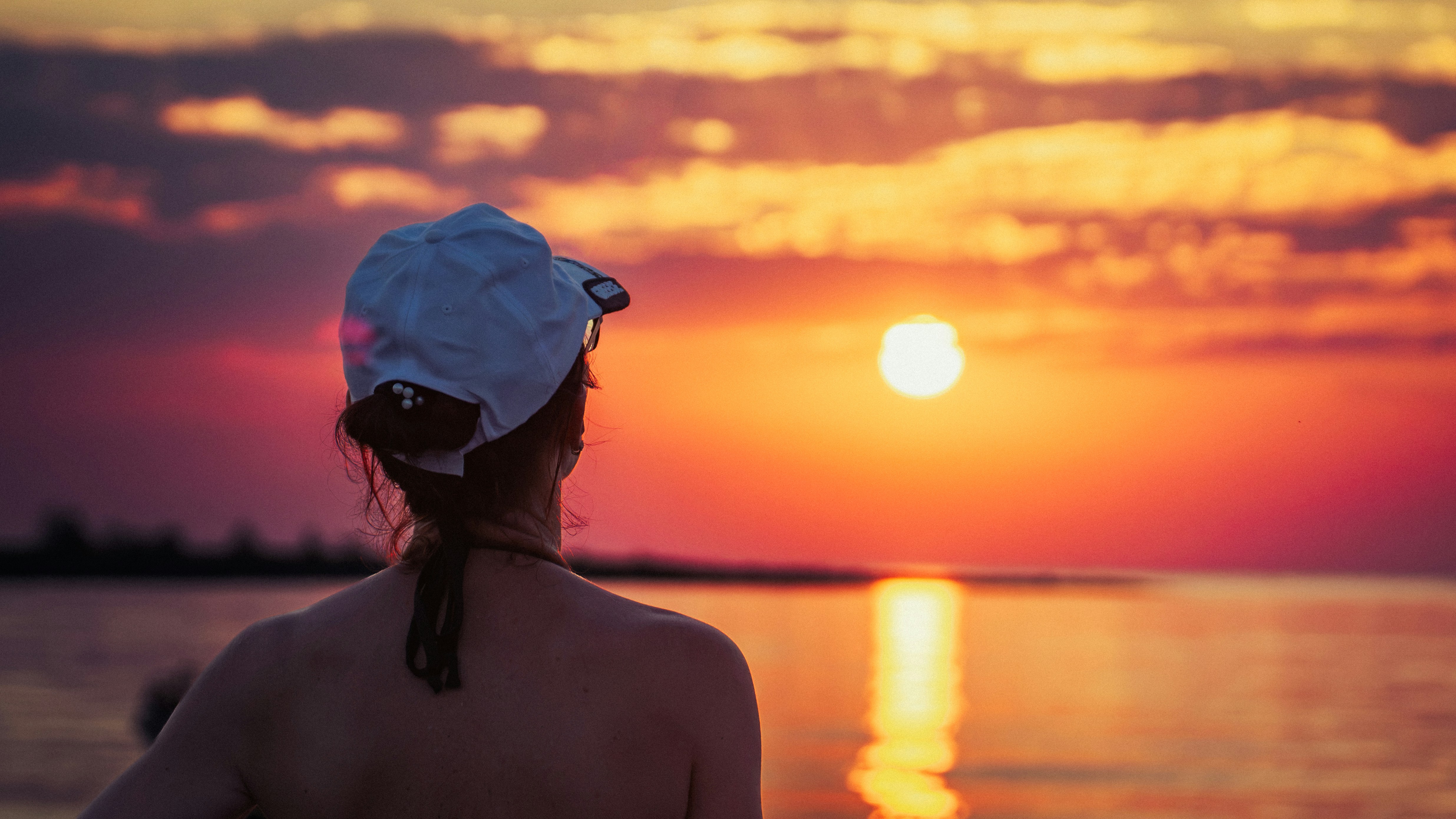 Backlit Silhouette at Sunset: A Lone Figure by Emerald Waters