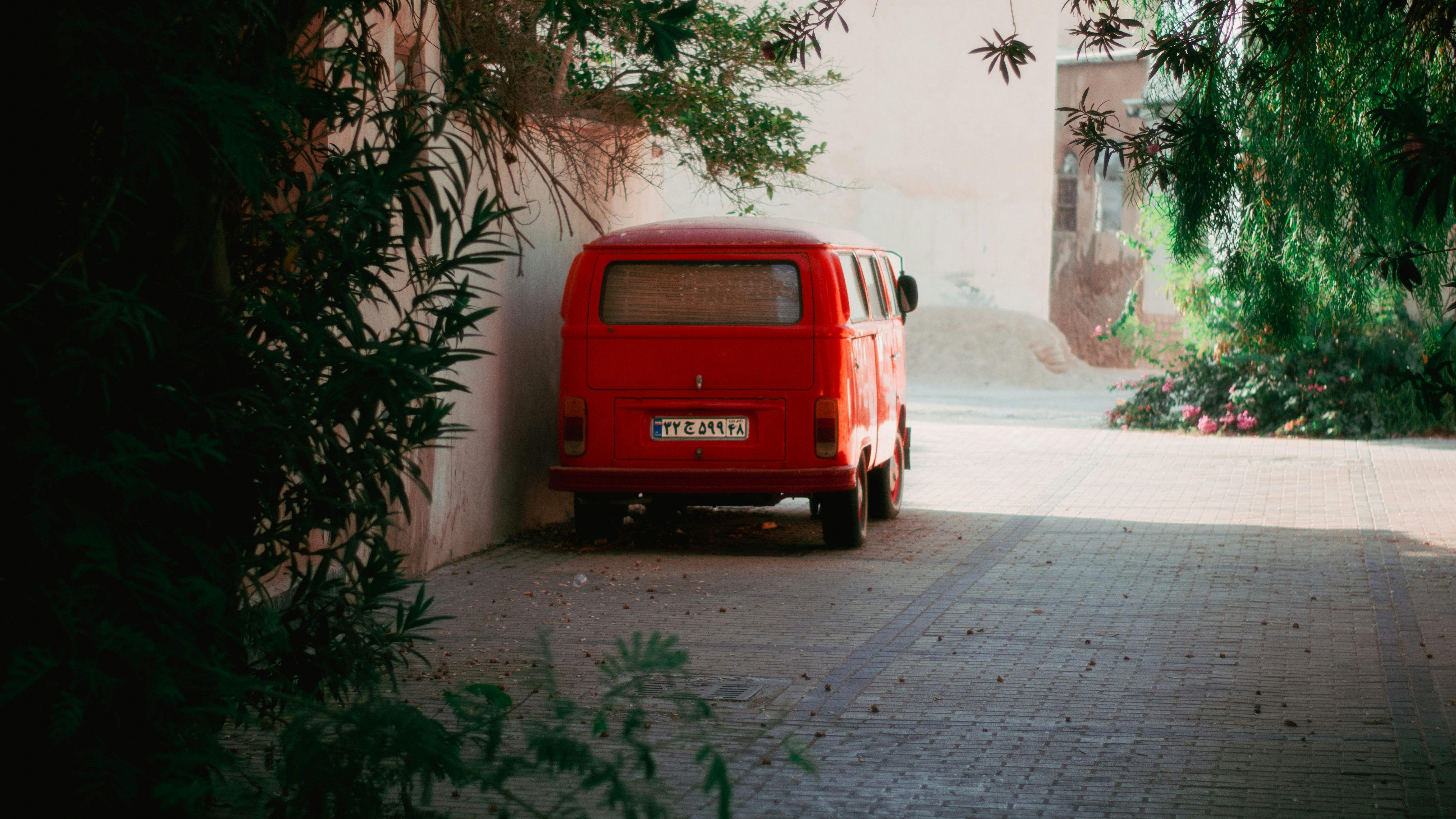 Red Volkswagen Van in a Shaded Courtyard