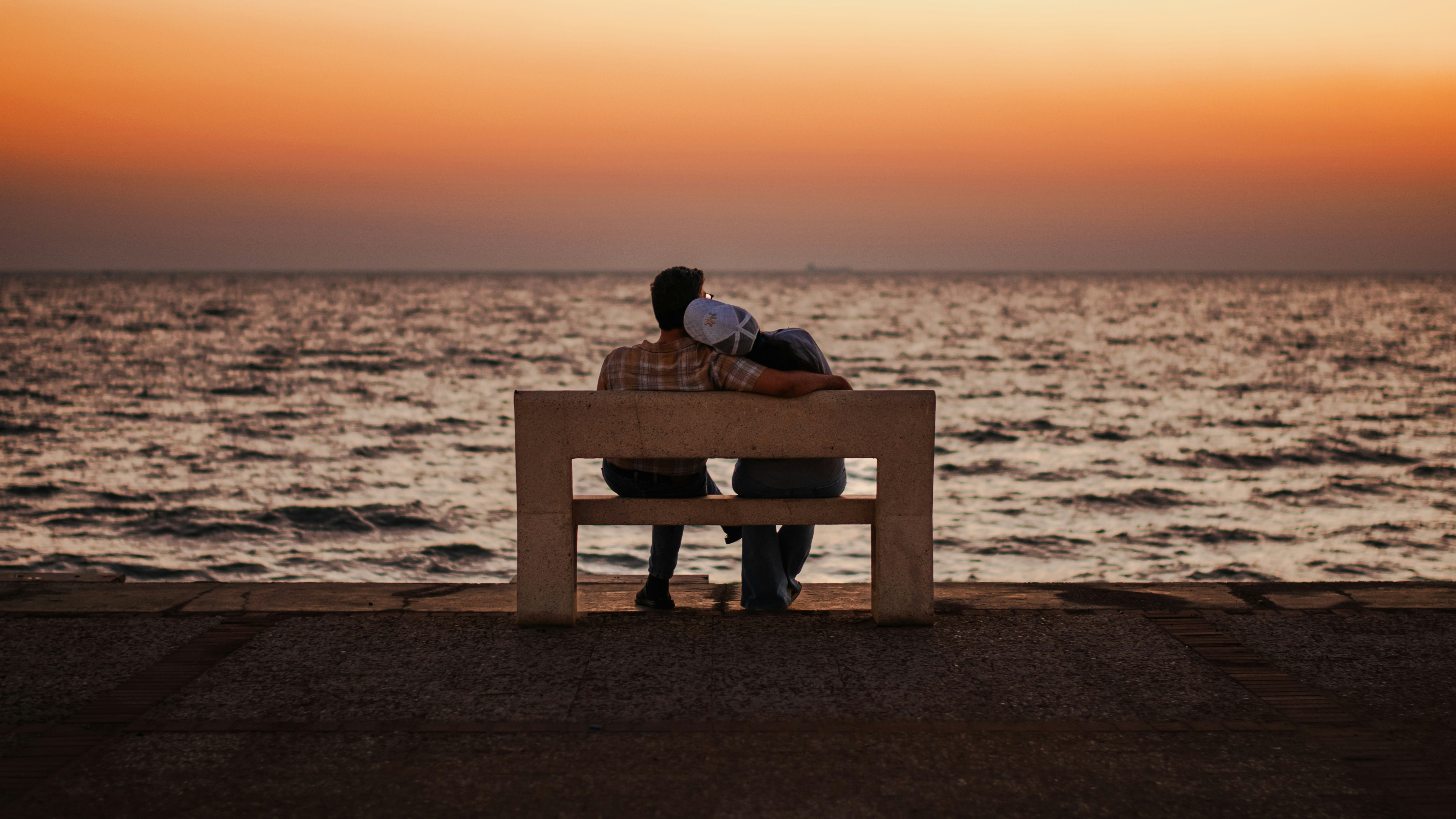 Sunset Silhouette: A Quiet Moment on the Bench by the Sea