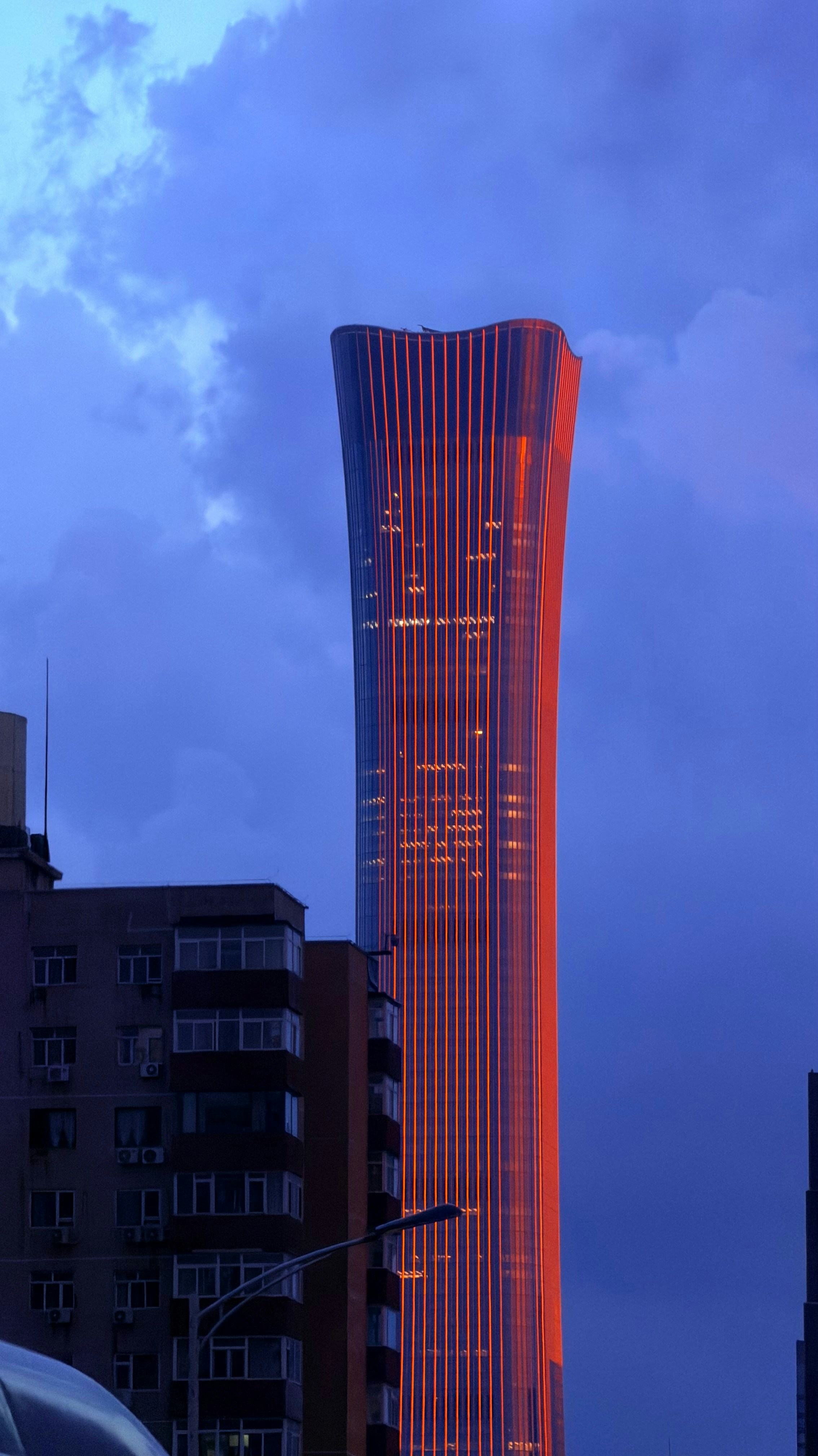 Sunlit Skybound: The Candy-Striped Tower Rising Over Quiet Blocks