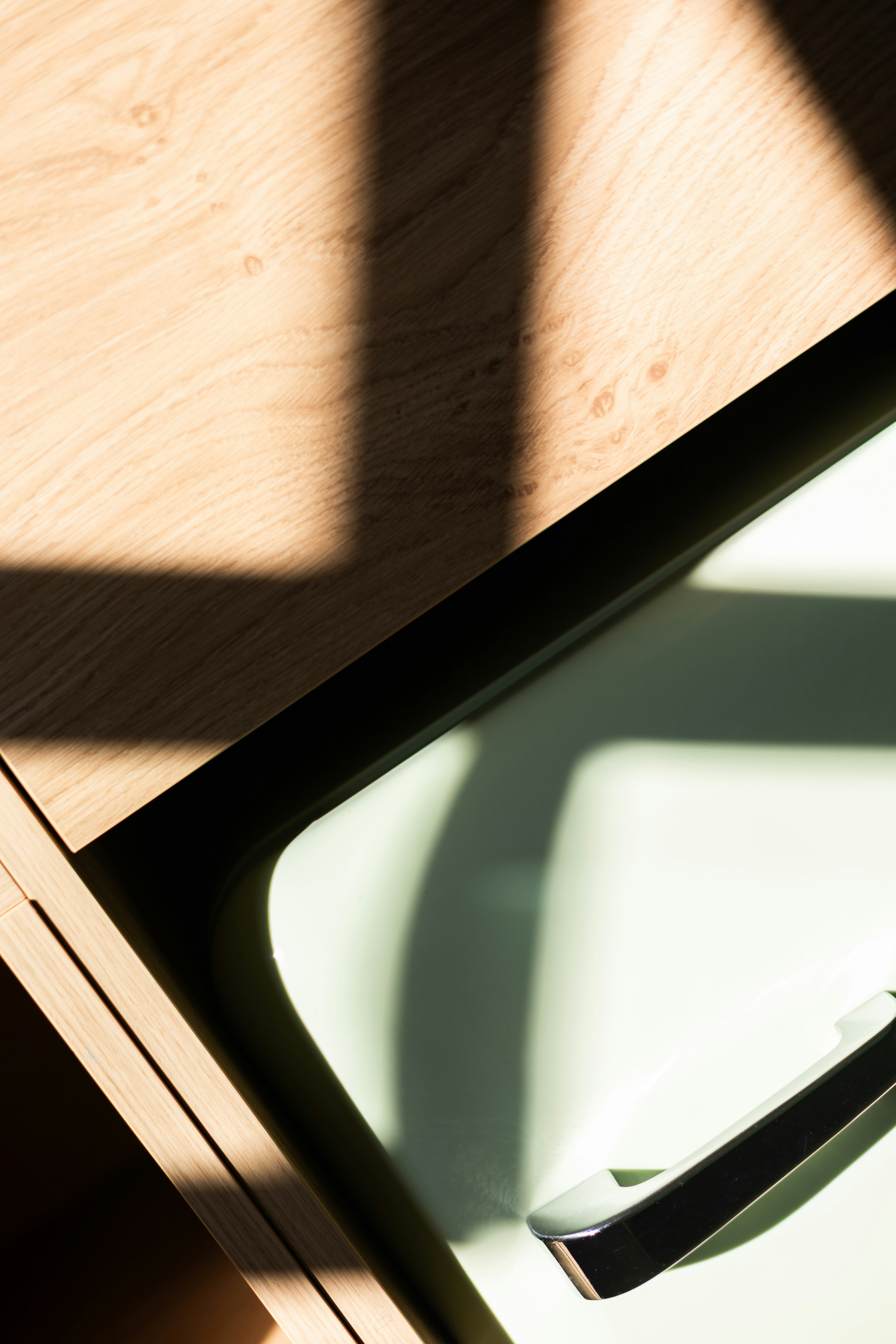 Shadowed Edge: Wooden Desk and Teal Chair Arm Casting Shape