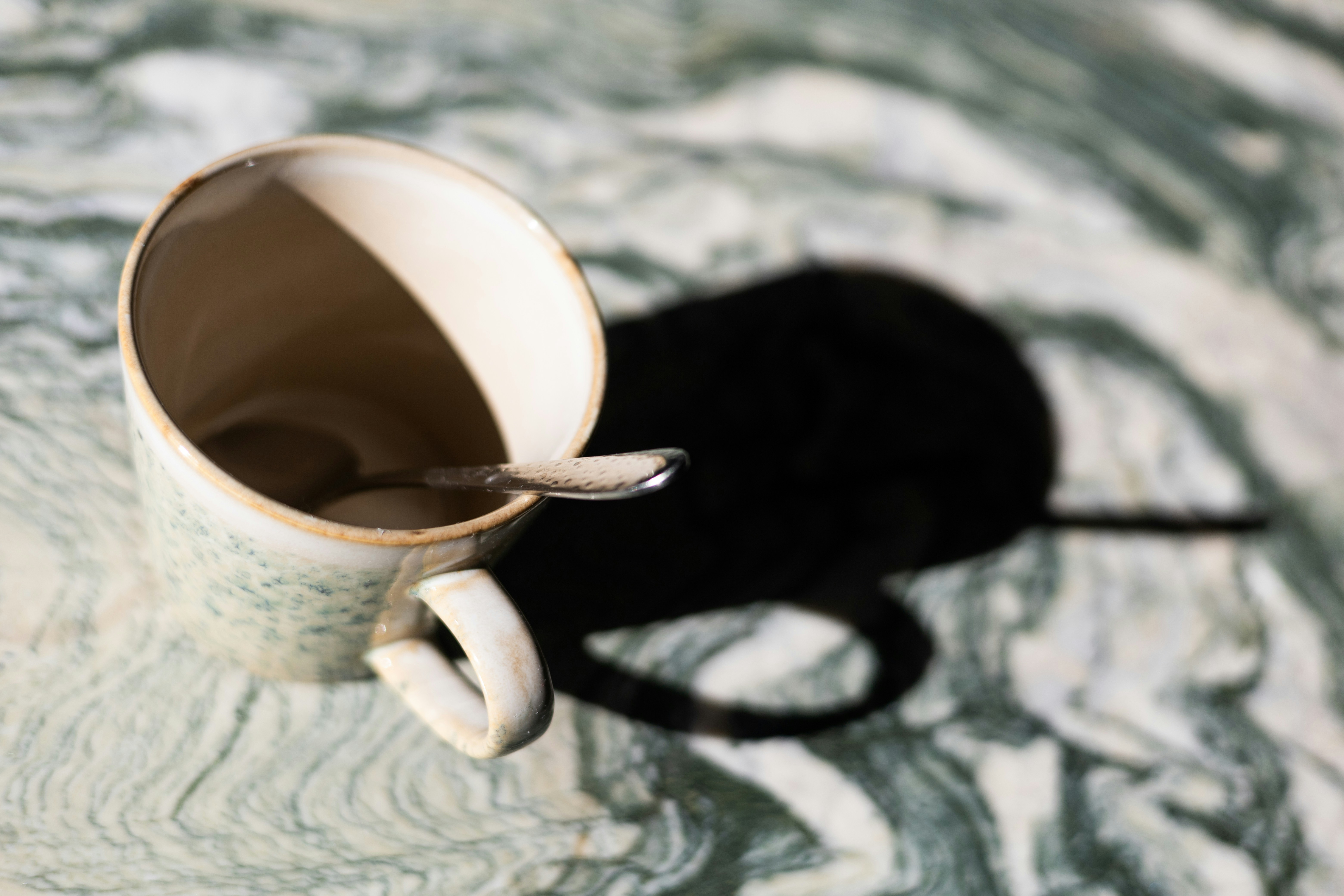 Tilted Mug Casts a Shadow Across Rippling Fabric