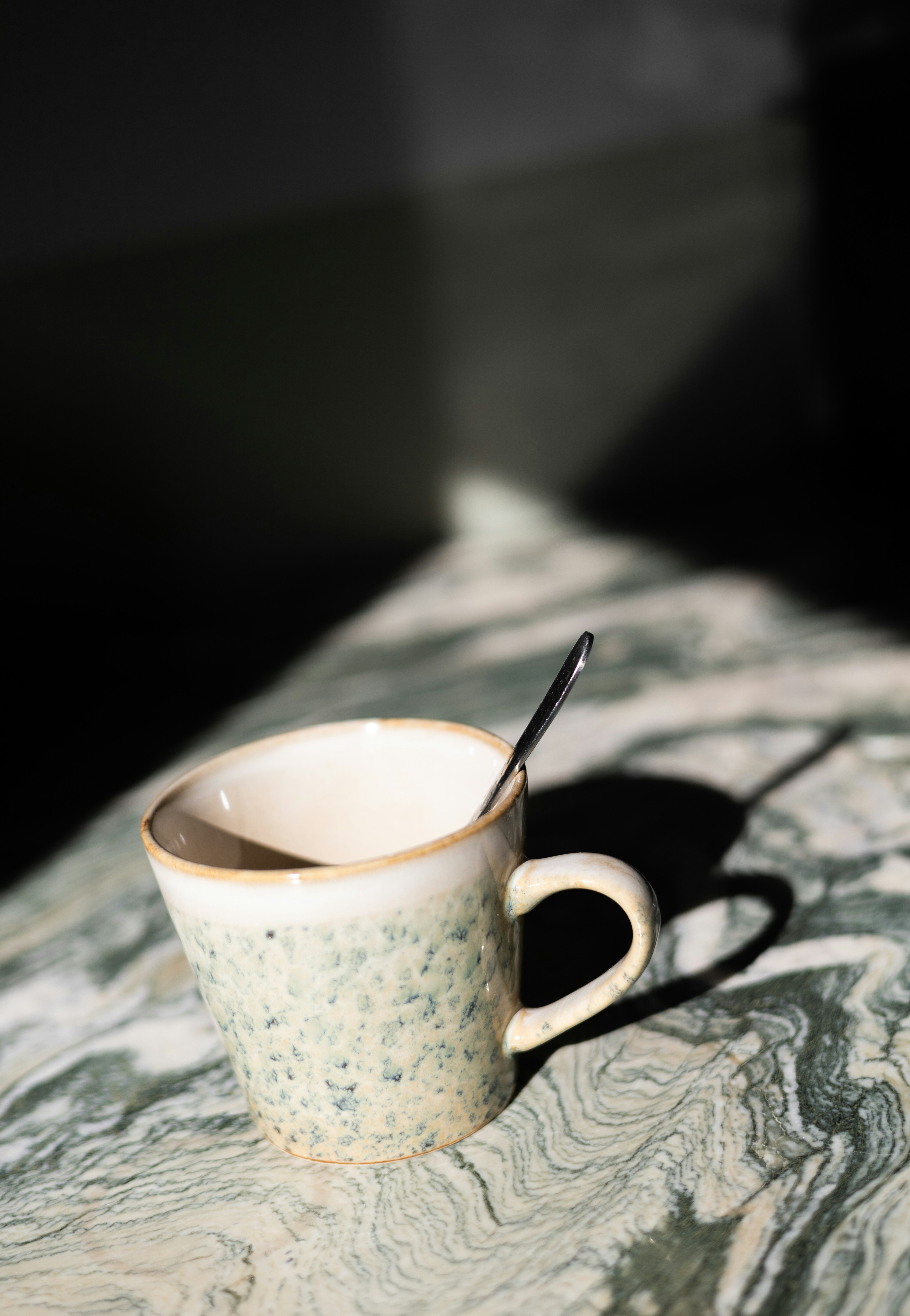 Morning Break: Speckled Mug with Spoon on Marble Counter