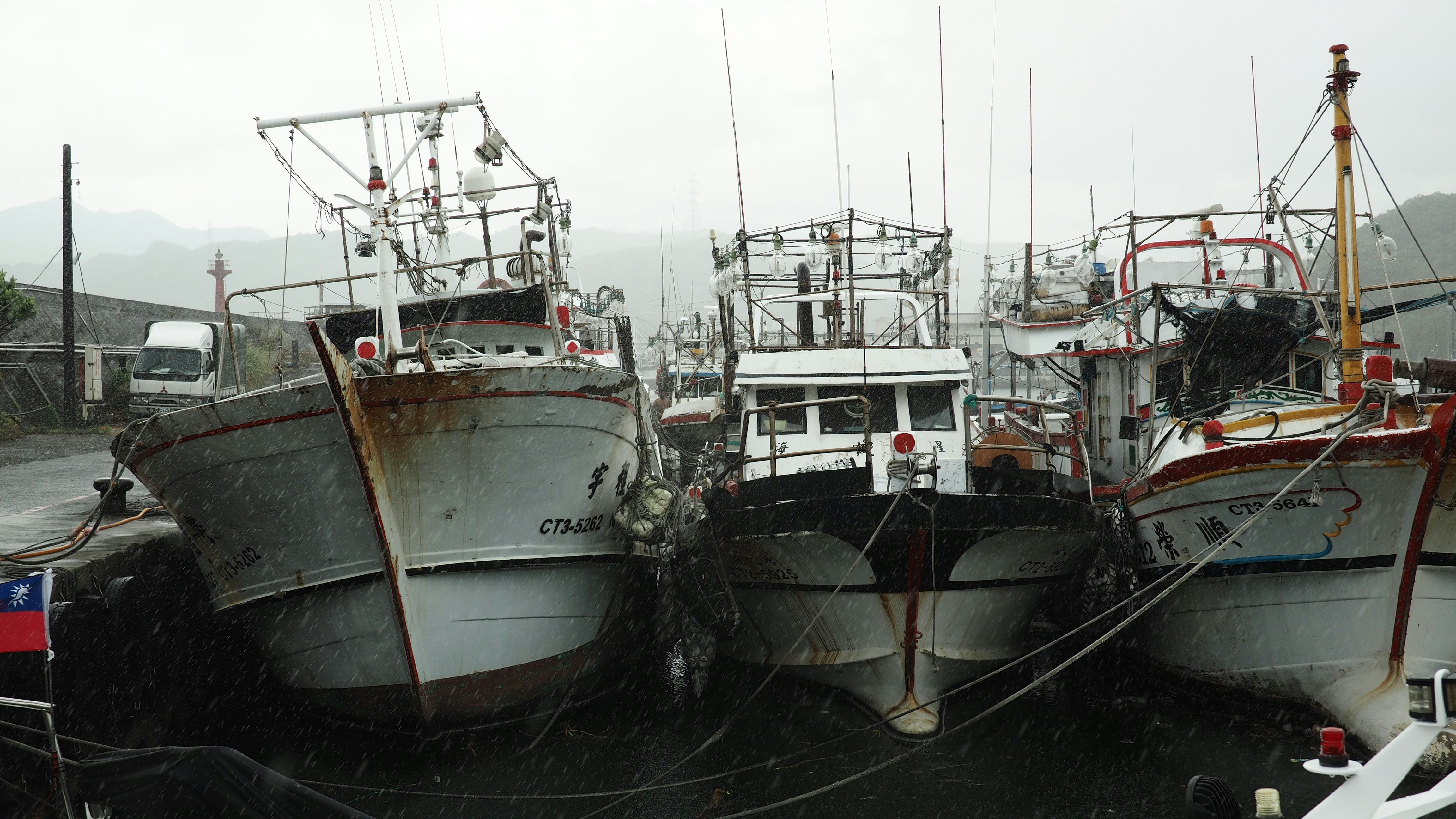Dockside Array: Weathered Fishing Vessels Rest Along the Wharf