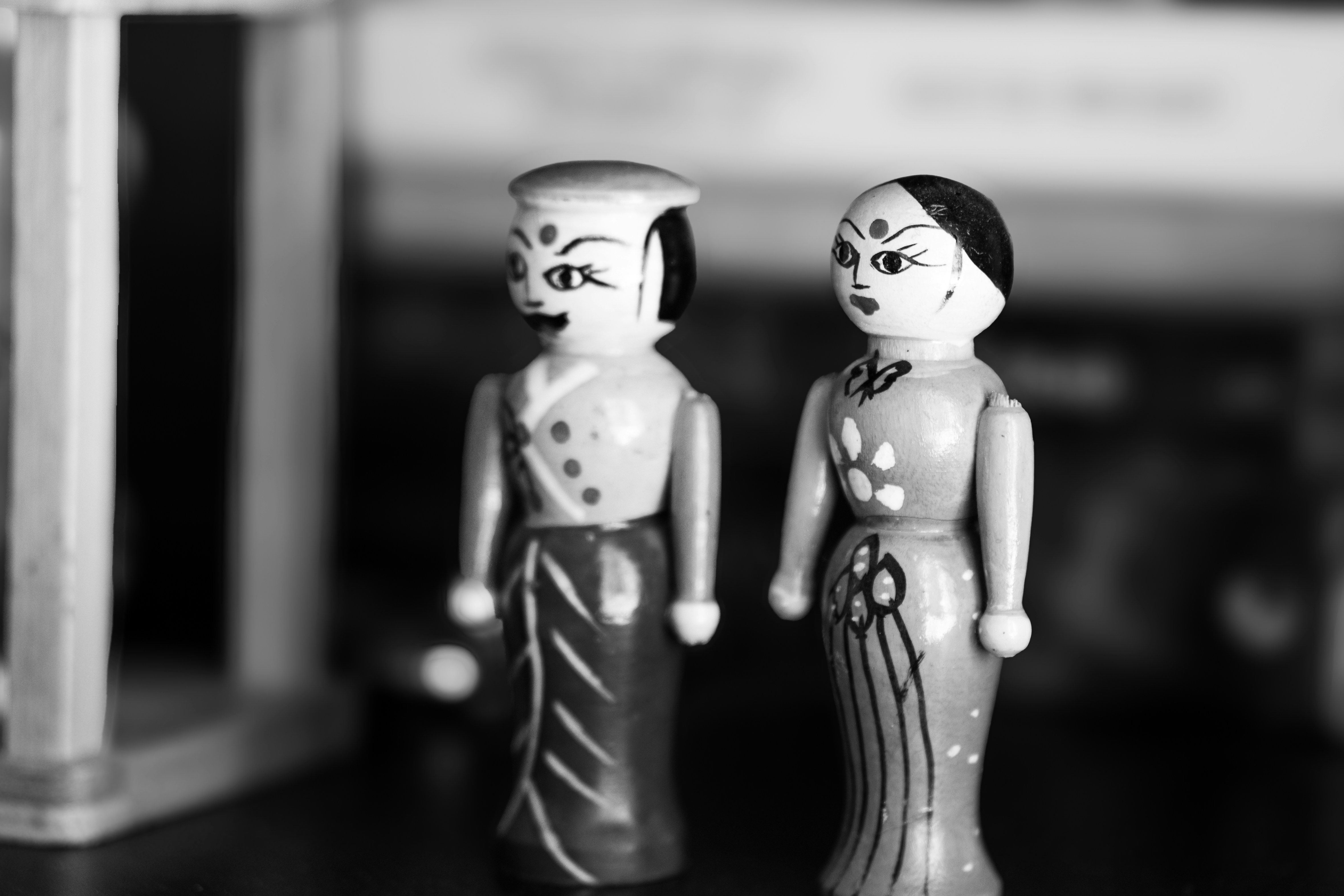 Two Wooden Figures in Focus: Quiet Portraits on a Dim Shelf