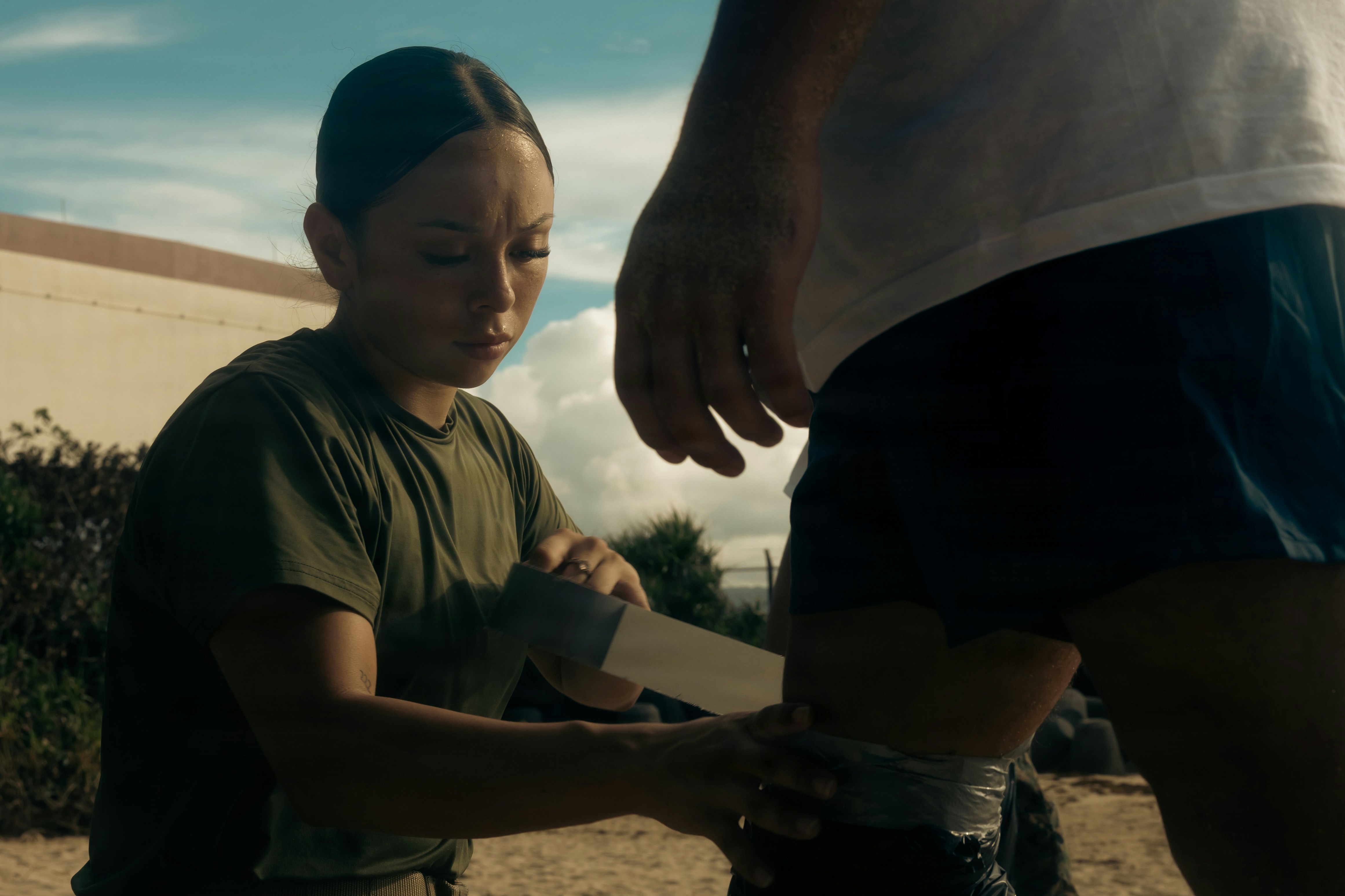 Scarred Truth: A Quiet Moment of First Aid on a Sunlit Field