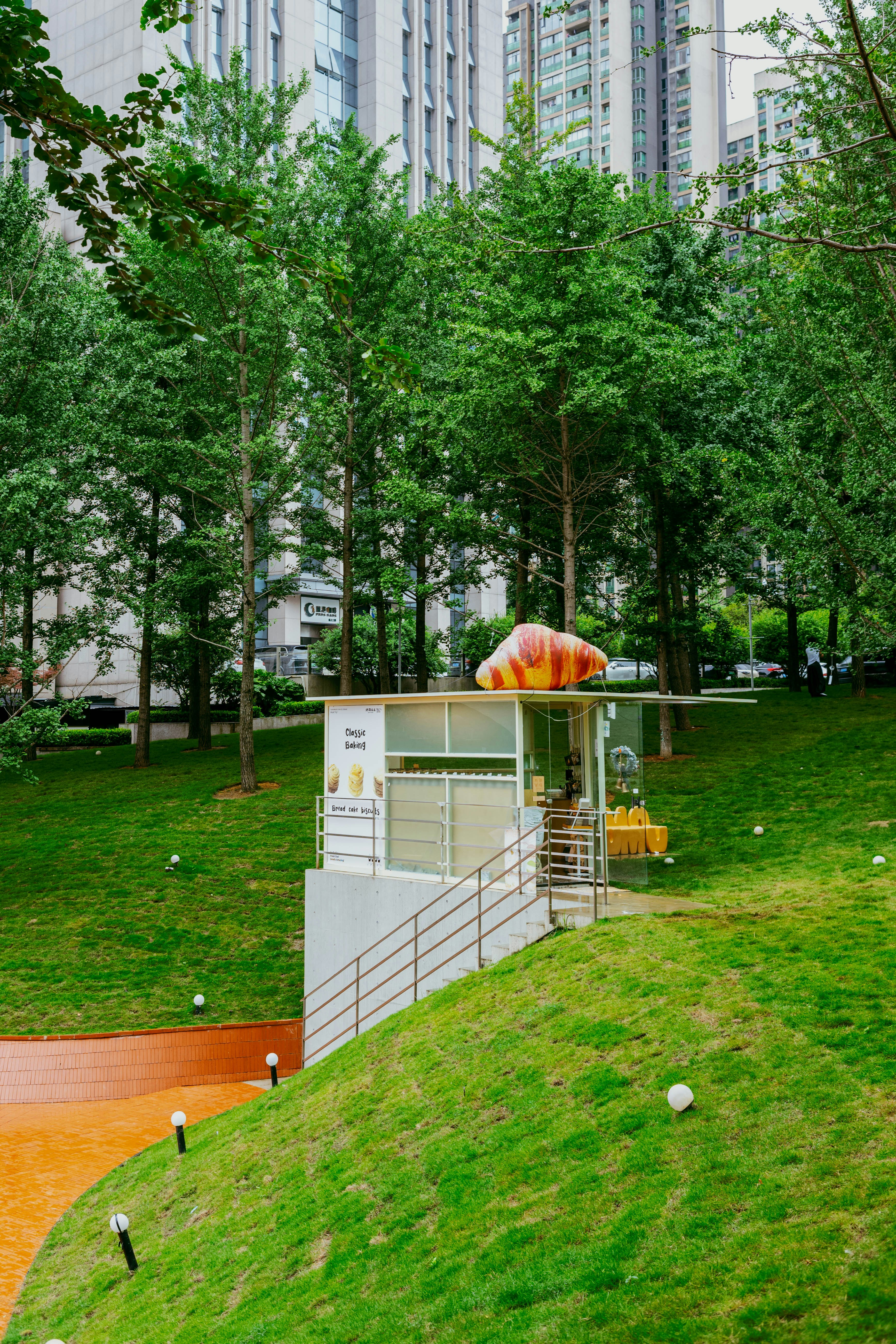 Urban oasis kiosk crowned with a pastry glow amid a city grove
