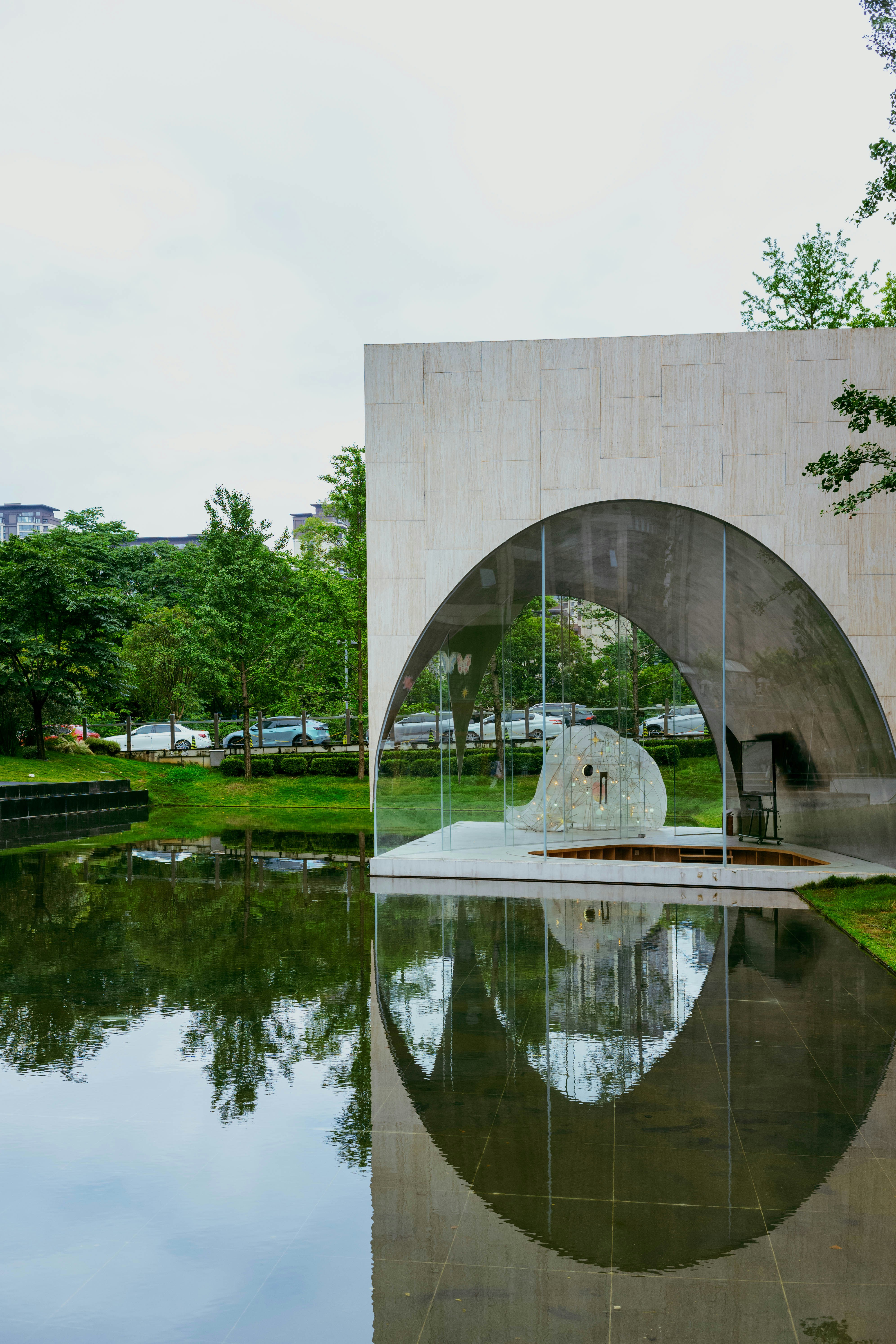 Circular Portal over Quiet Pond: A Modern Monument Reflected