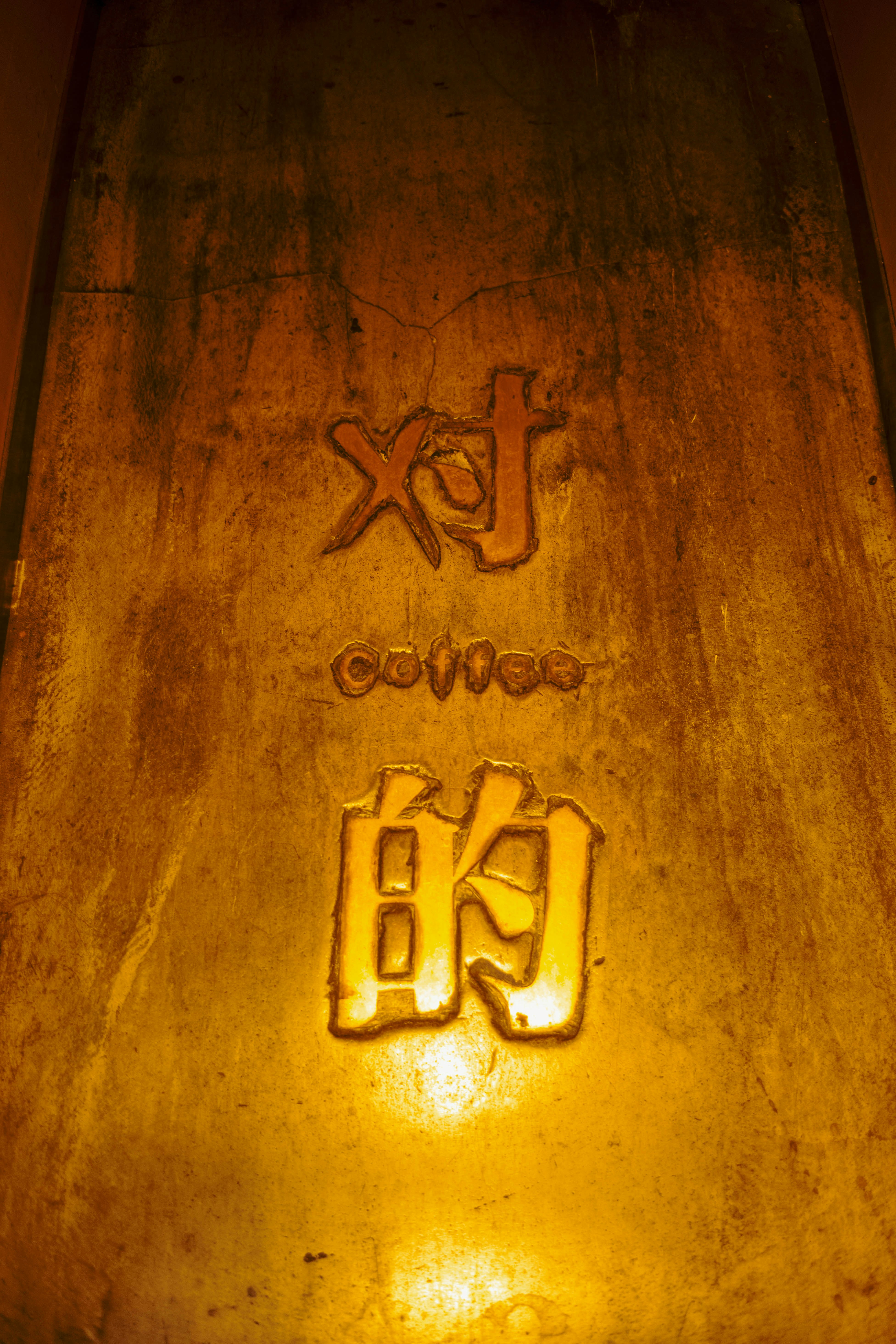 Warm Carved Signage in Dim Amber Light