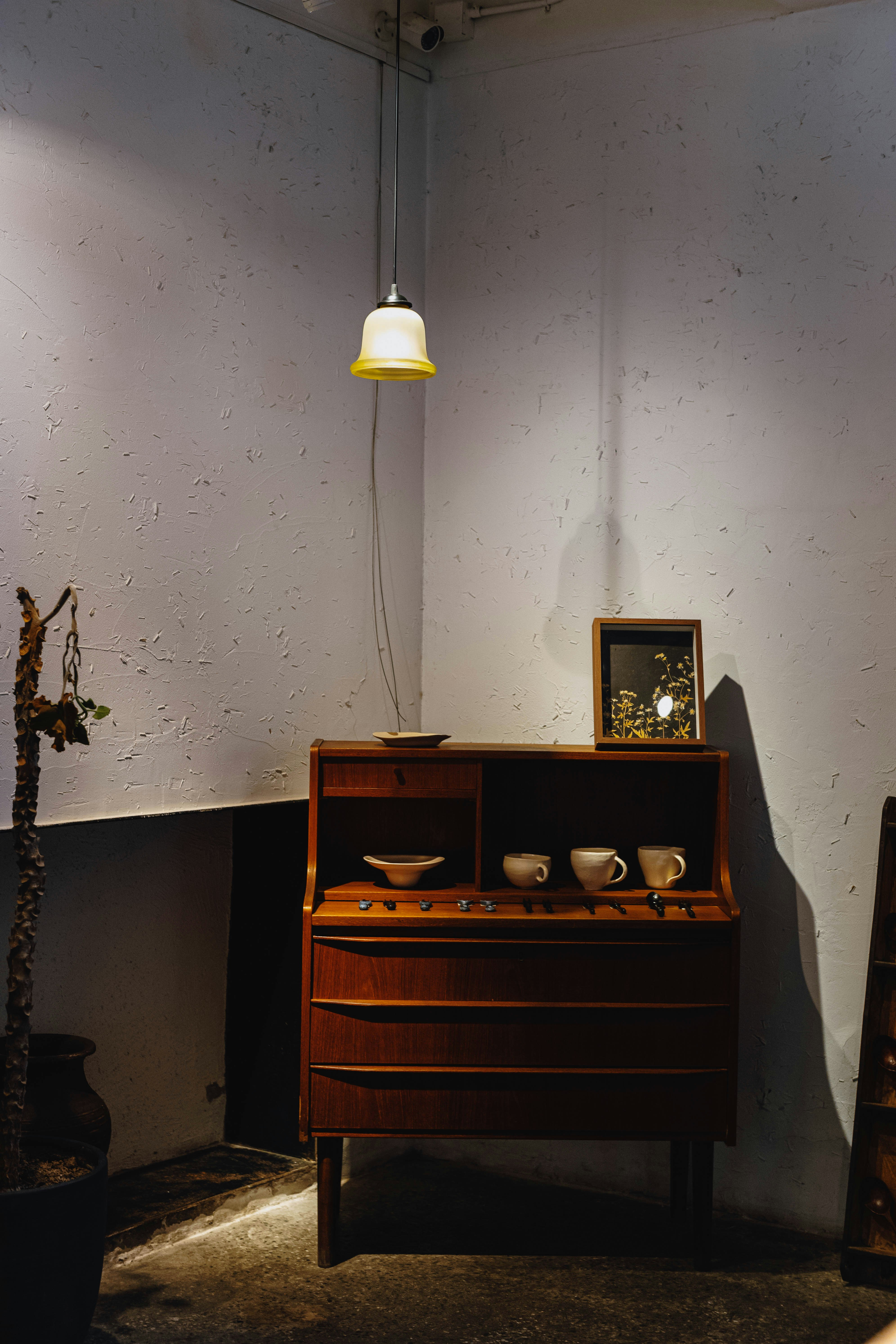 Mid-century Stillness: A Lamp-lit Corner and Teacup Cabinet