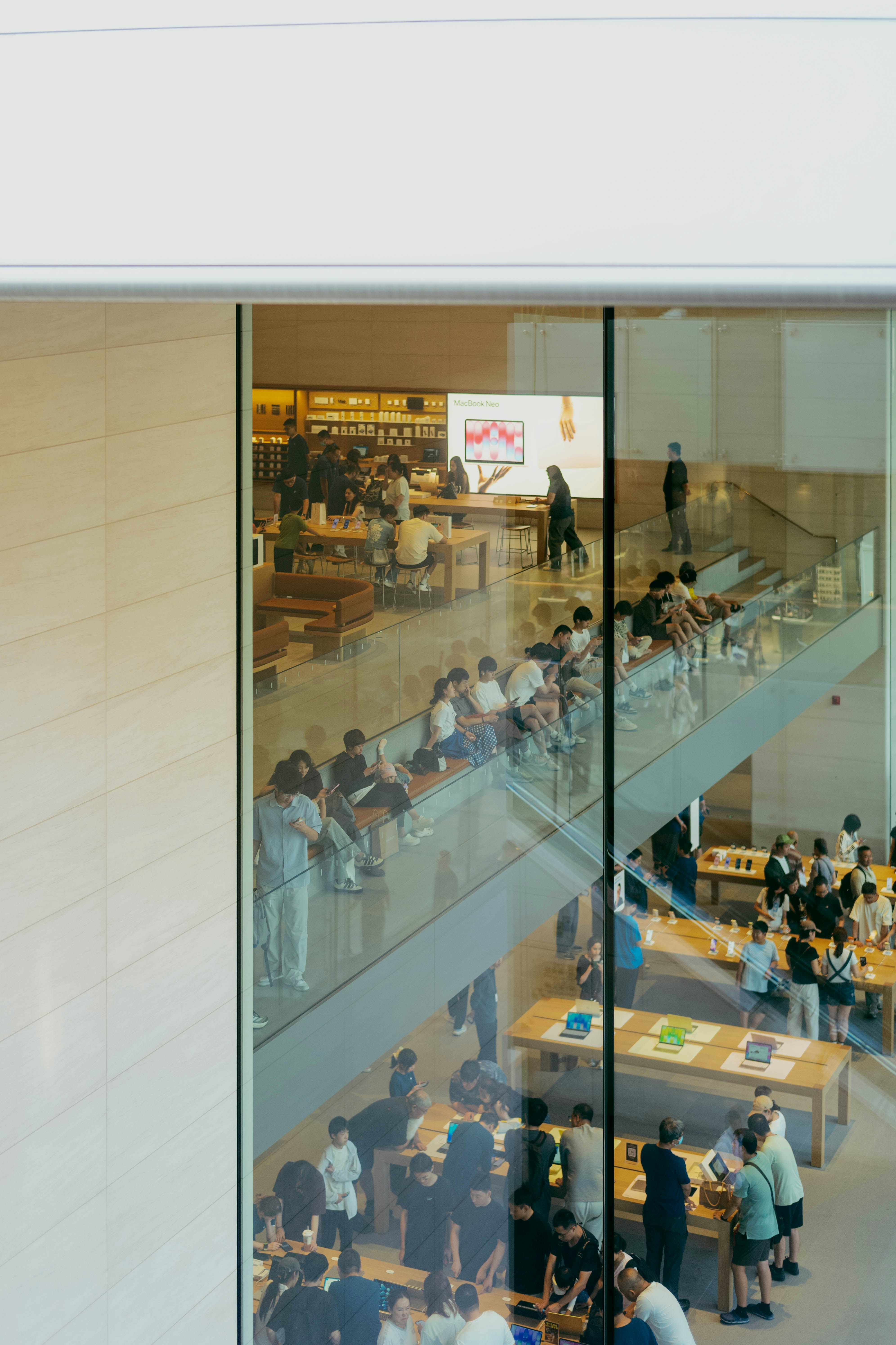 Glass-walled atrium bustle: people at work and rest above and below