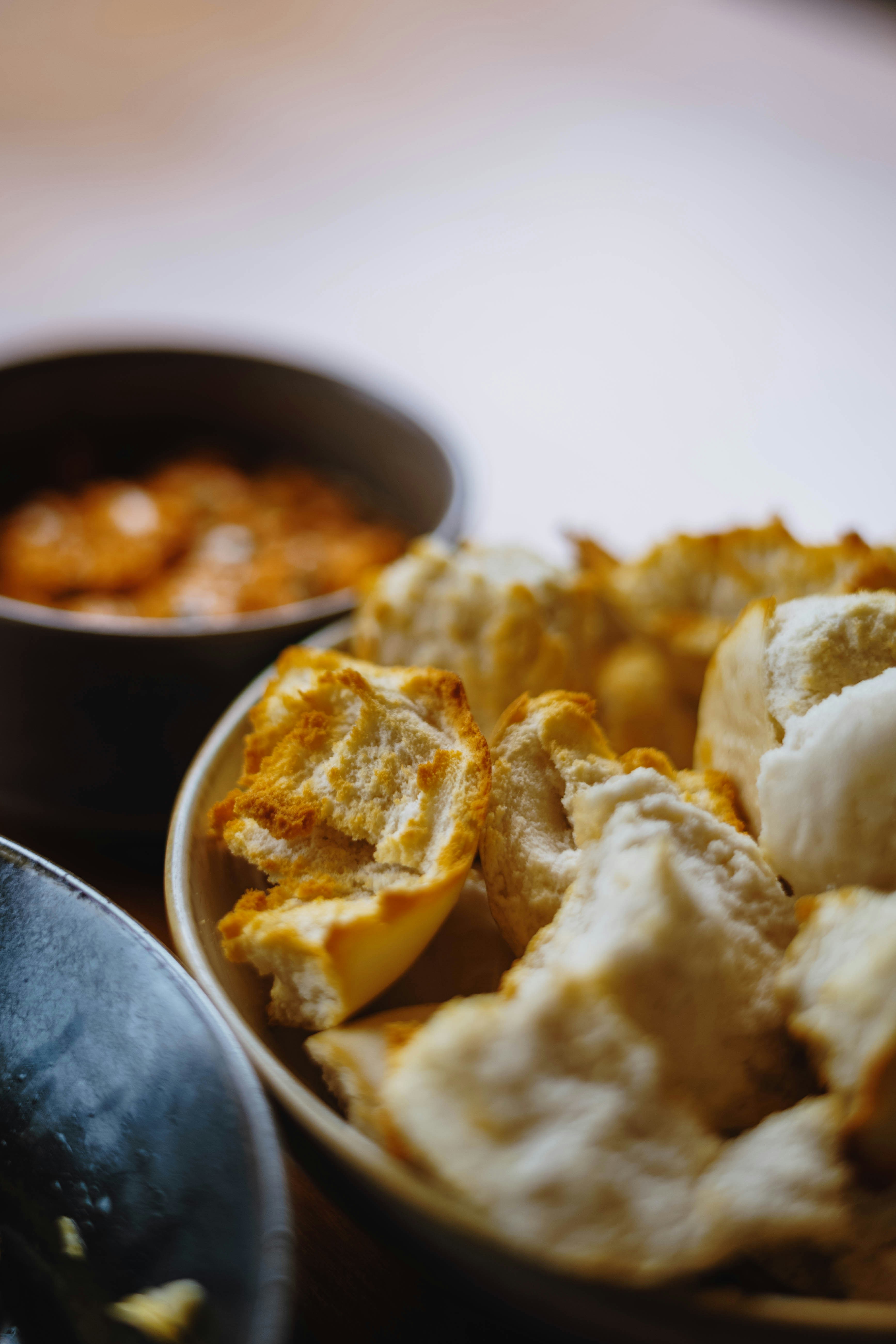 Golden Crunch: Assorted Dips and Bread Fragments in a Rustic Bowl