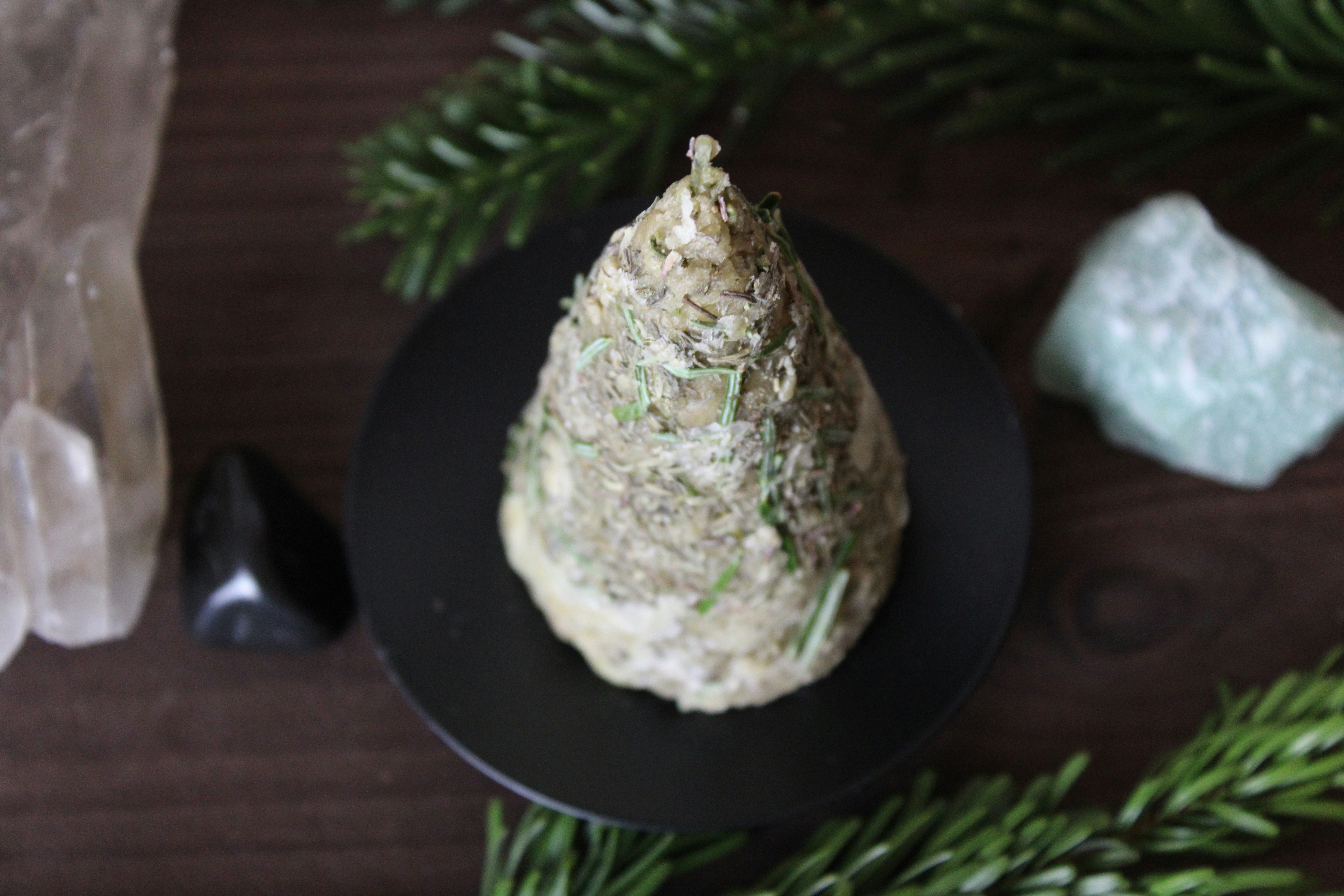 Herb-crusted cone centerpiece on a dark plate