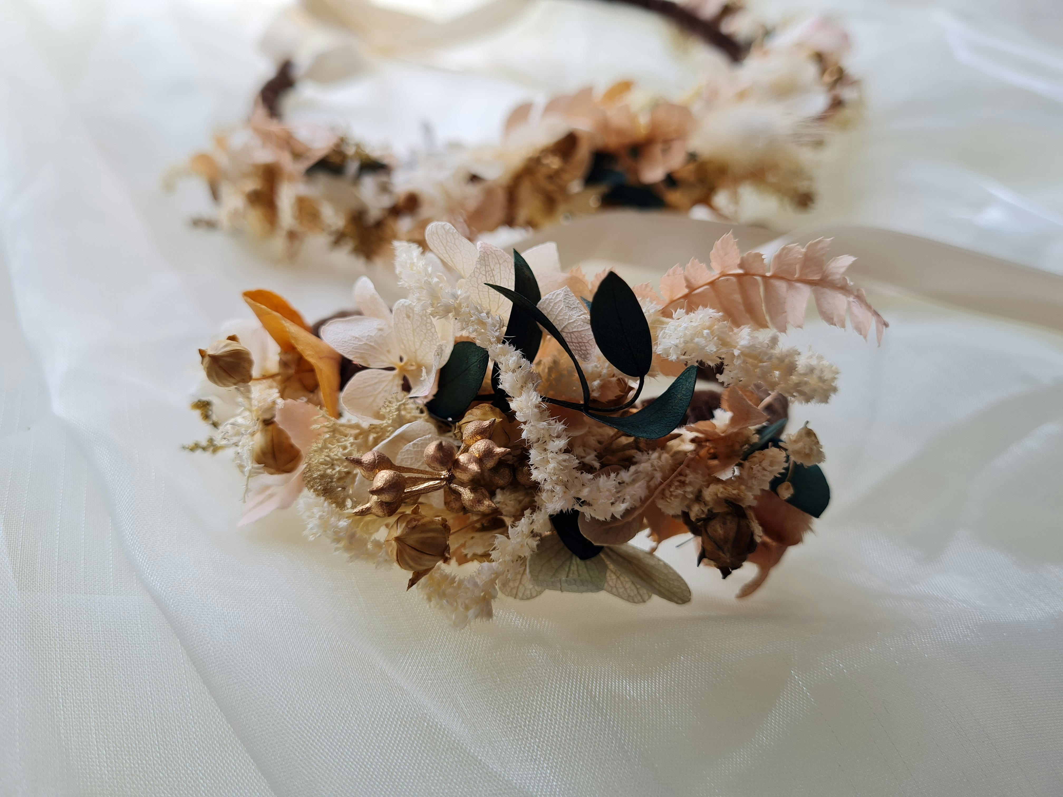 Dried-flower bouquet resting on ivory fabric with soft wrap