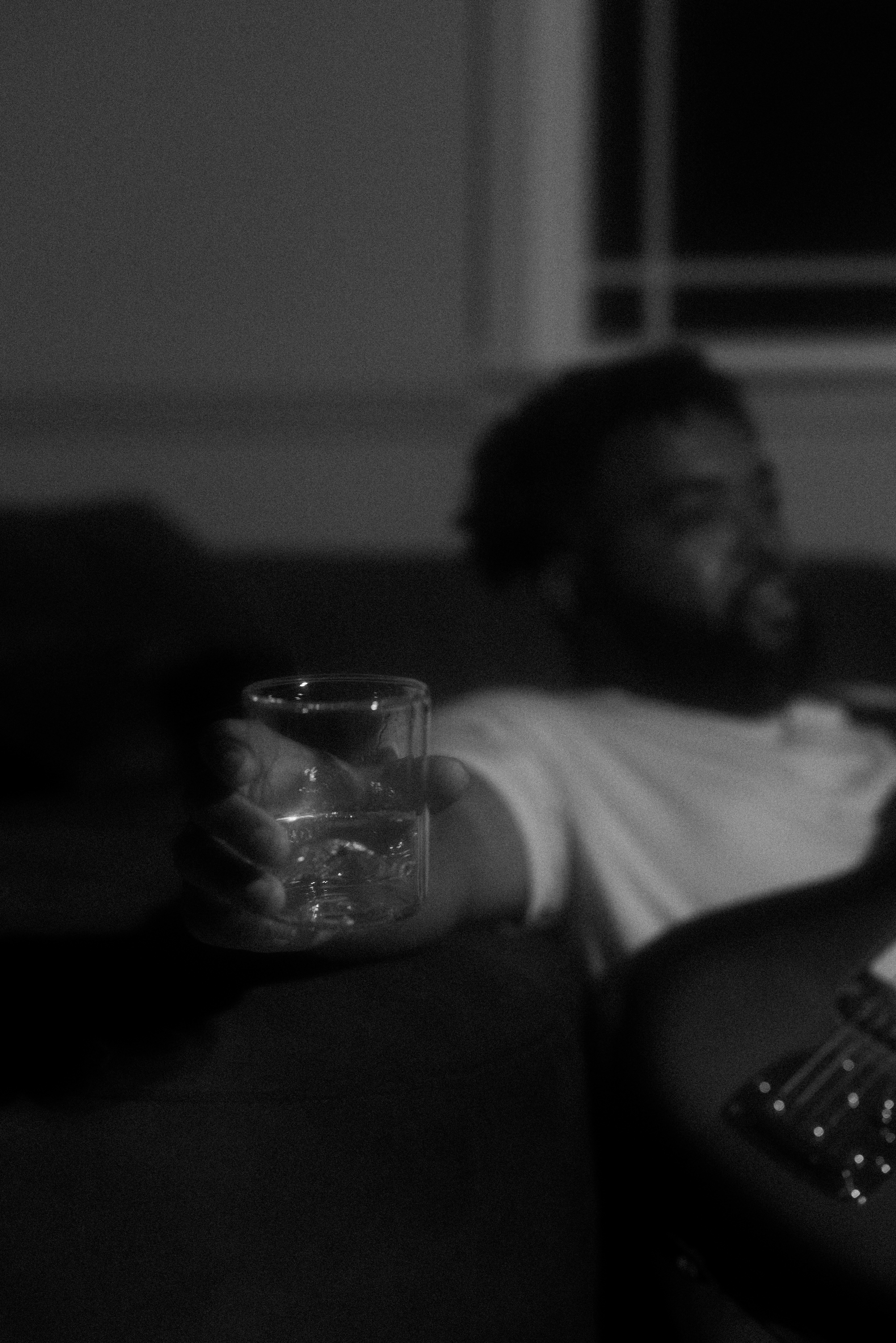 Glass in hand, guitarist reclining in dim living room