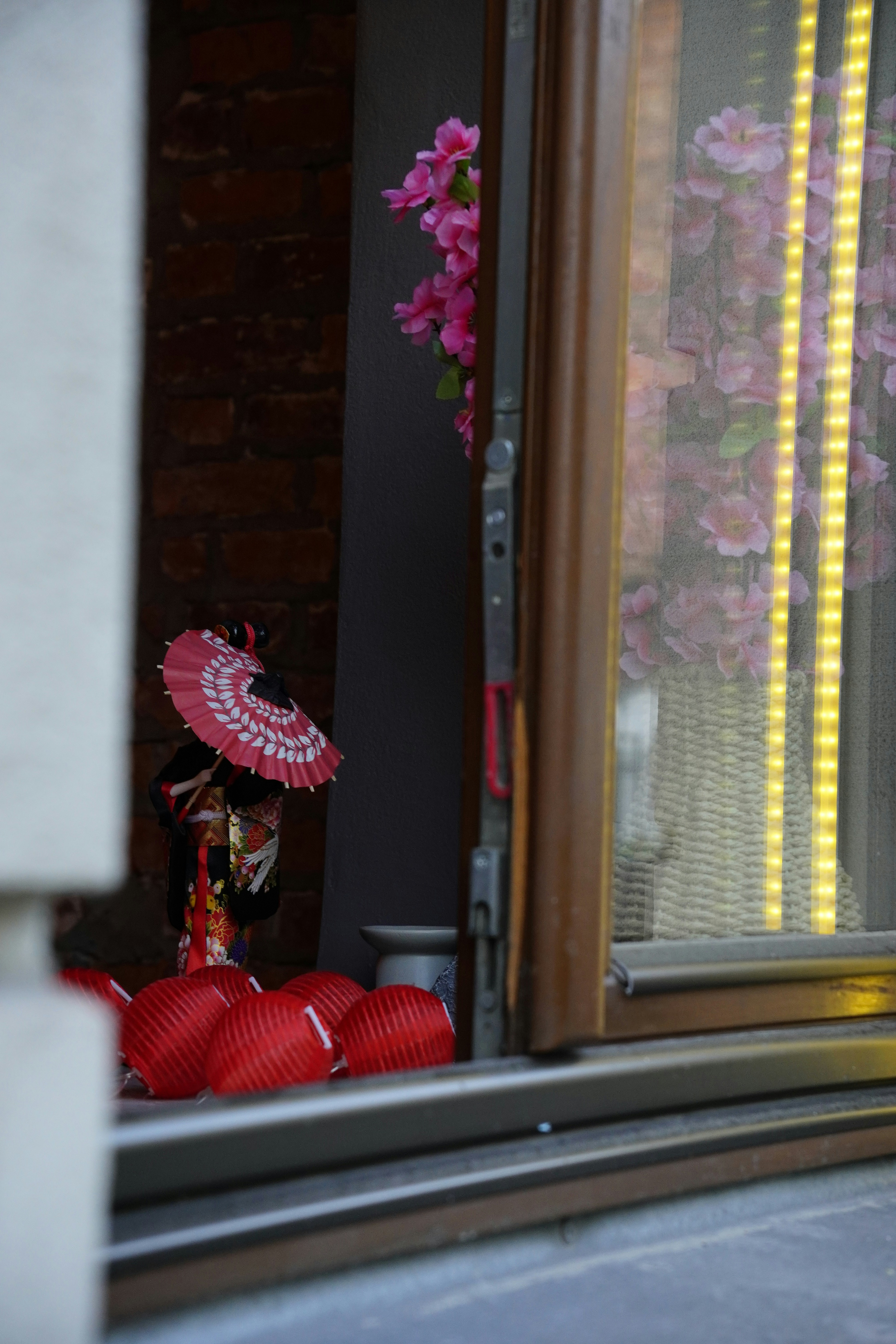Lanterns and pink blossoms at a street doorway