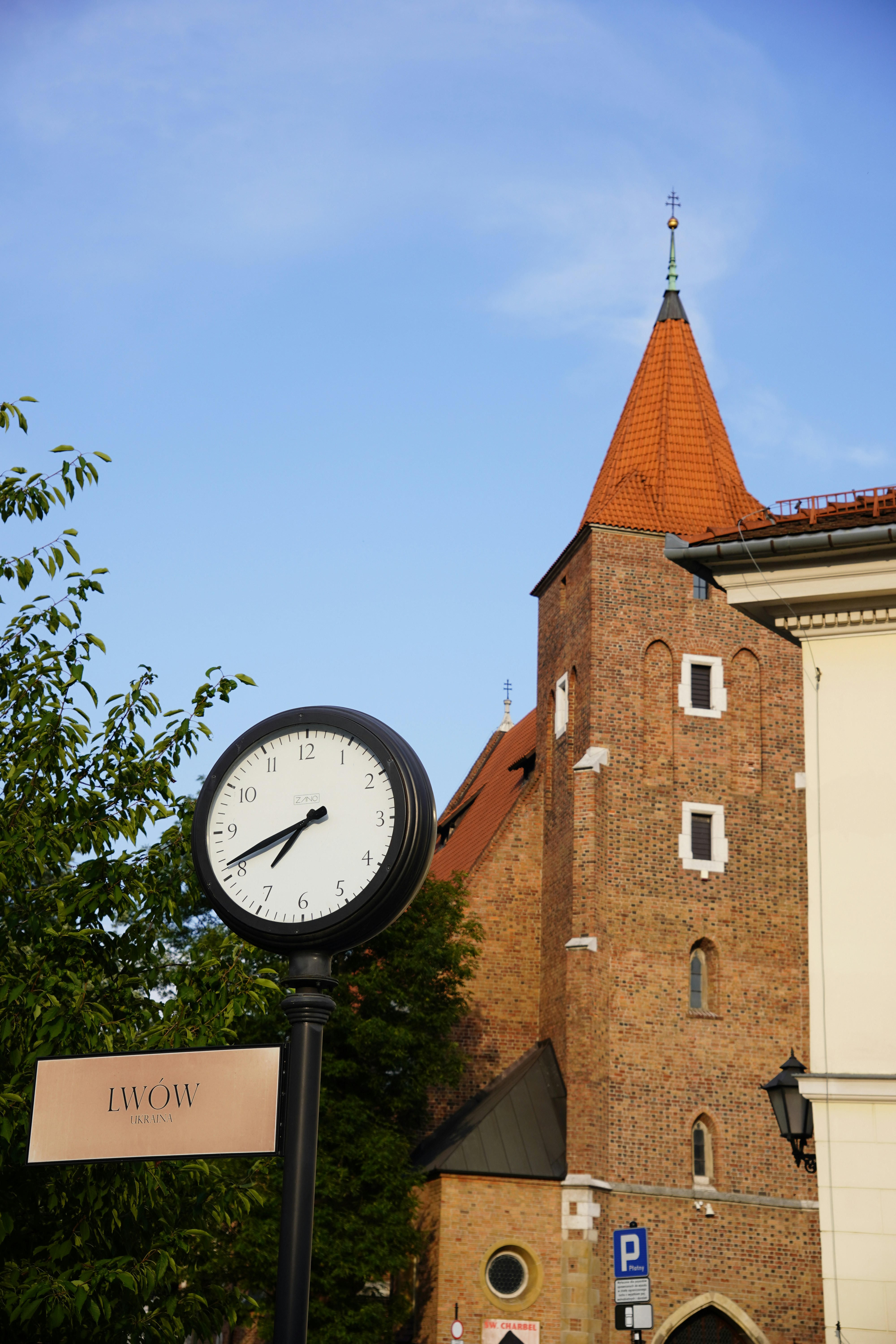 Clock Tower and Brick Facade Under a Clear Blue Sky
