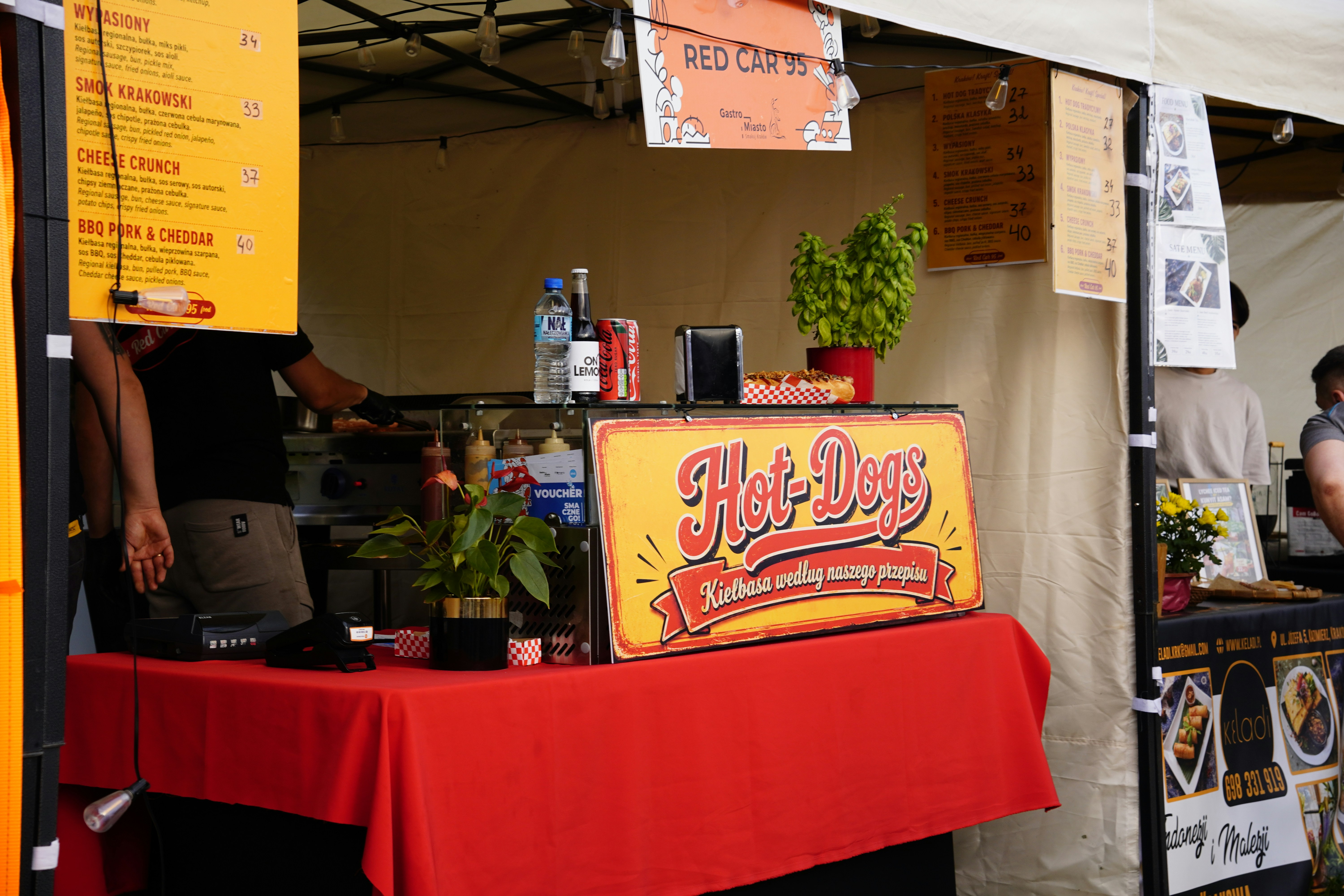 Grill Stand with Hot-Dogs Aglow Under Tent Sign