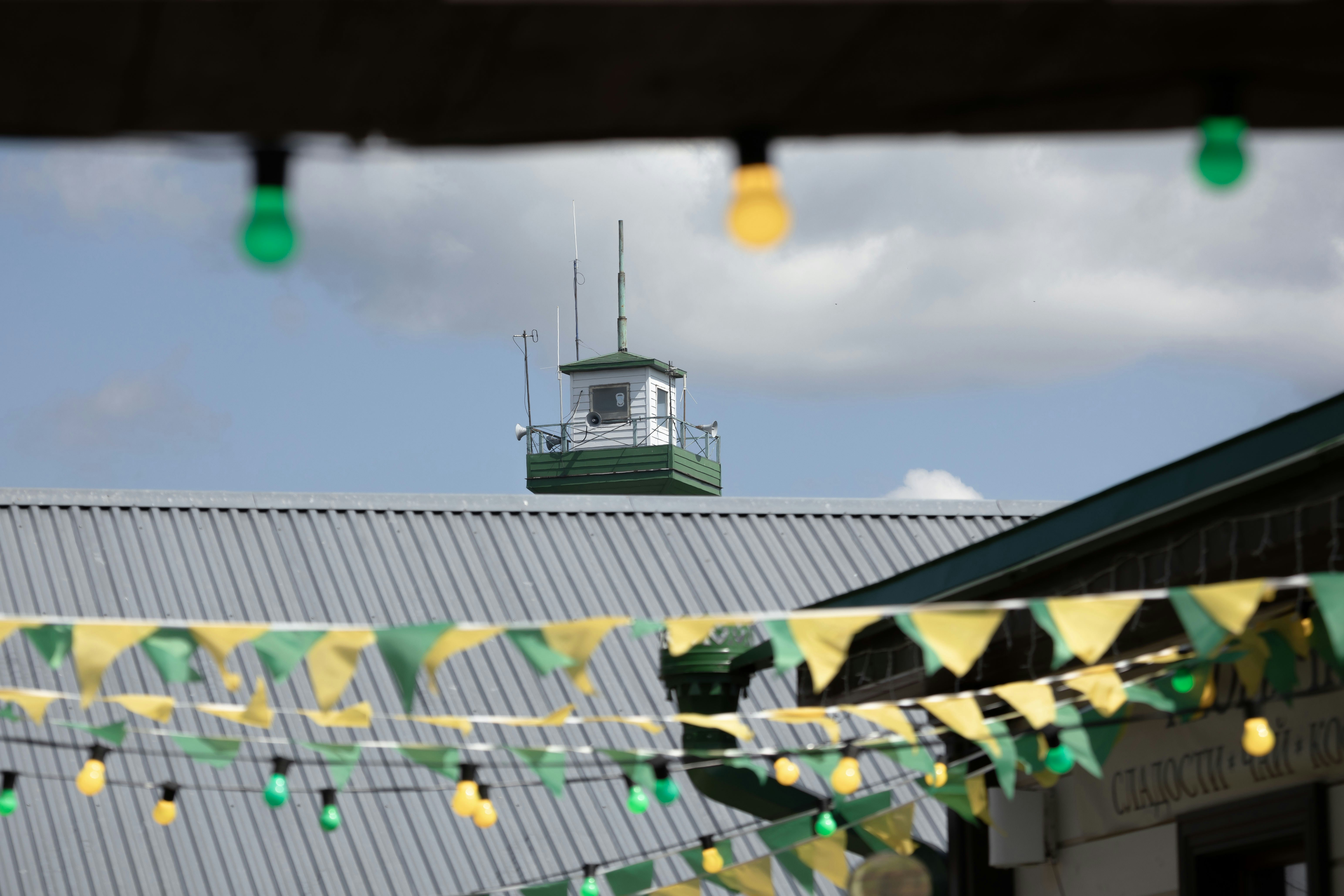 Varsity Clocktower Above Festive Rooftop Flags