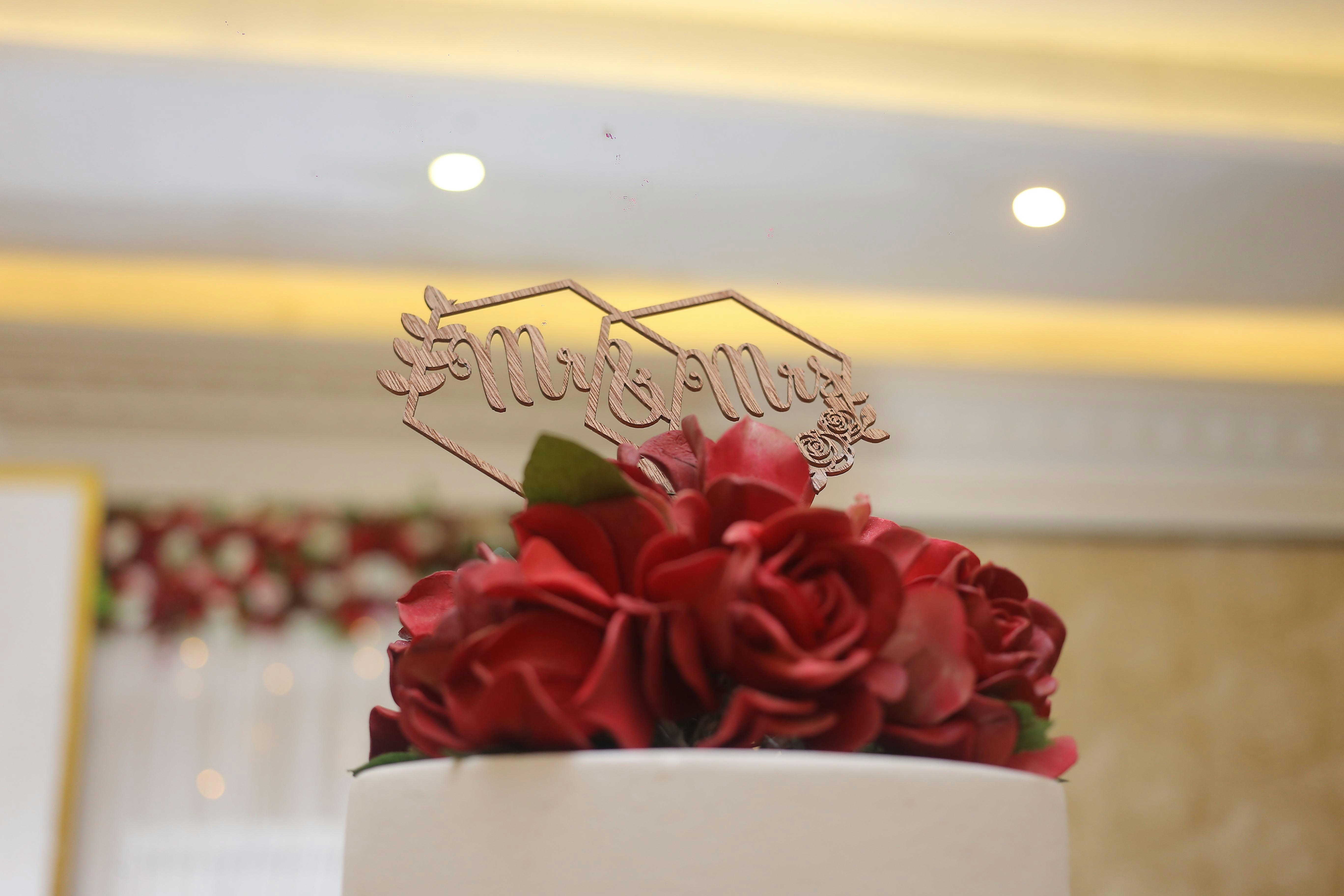 Blooms atop a wedding cake crowned with a metallic monogram