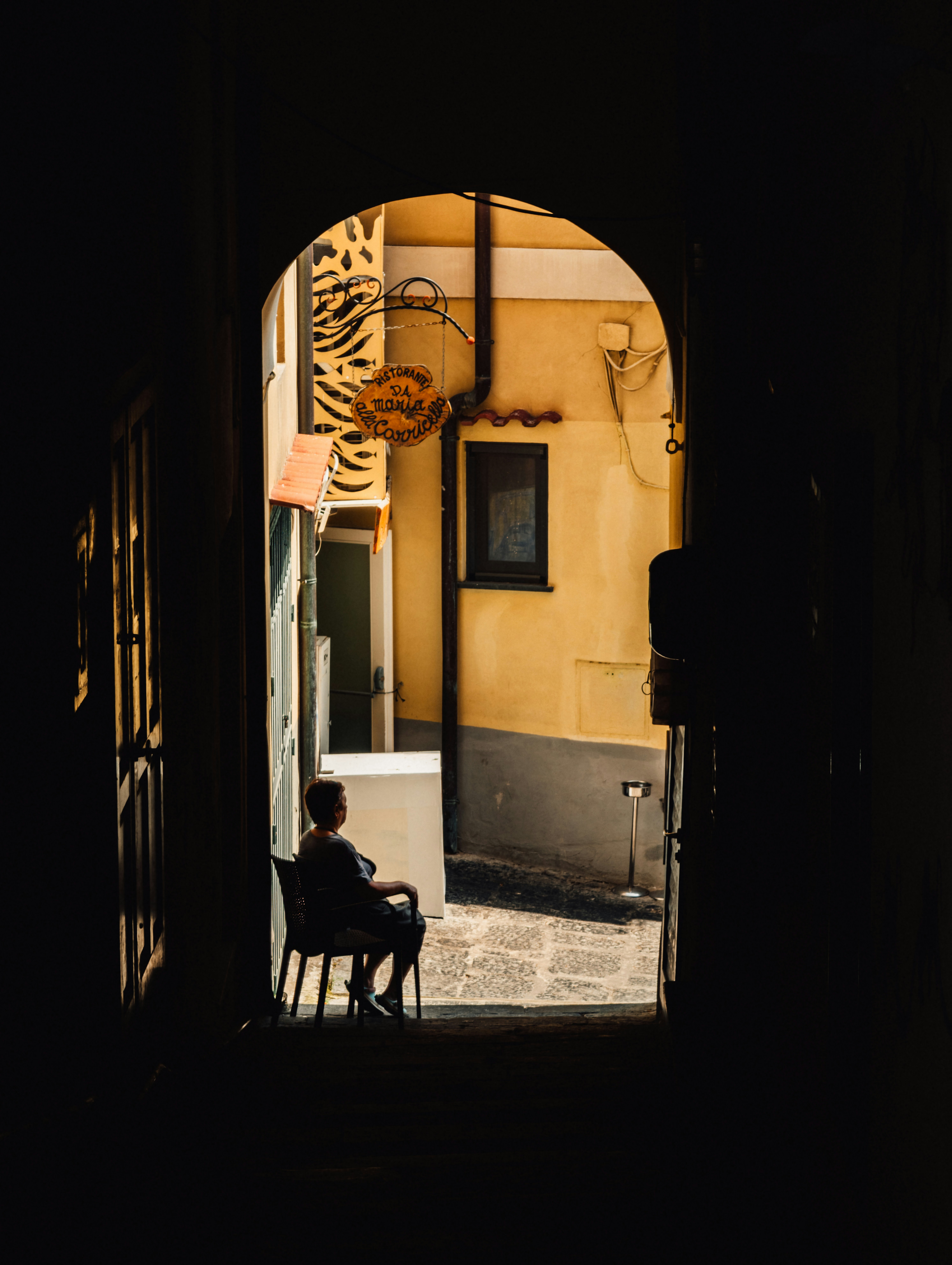 Silhouette in the Arch: A Quiet Moment in the Alley