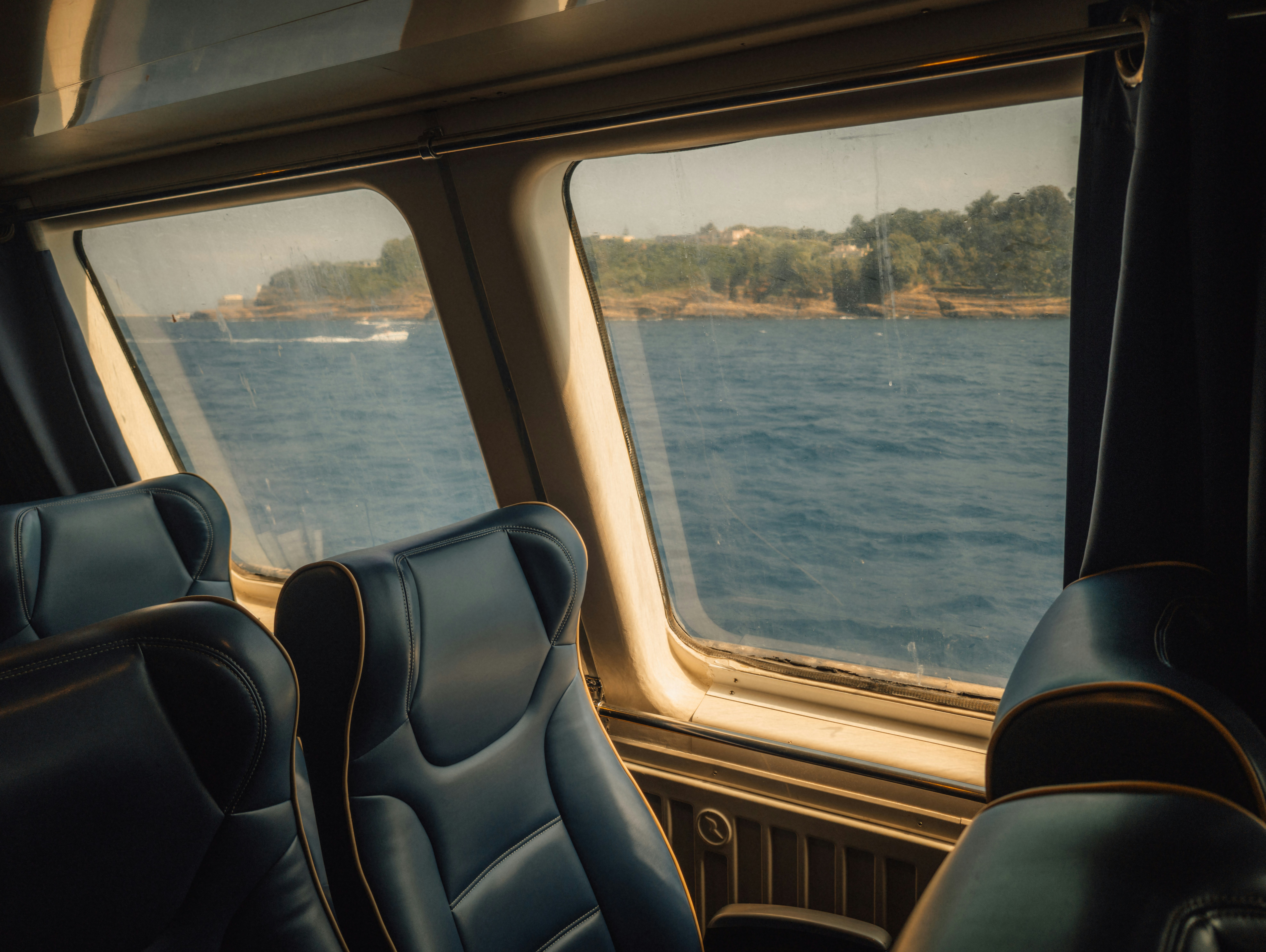 Blue Cabin Windows: Sea View Through Aisle of Seats