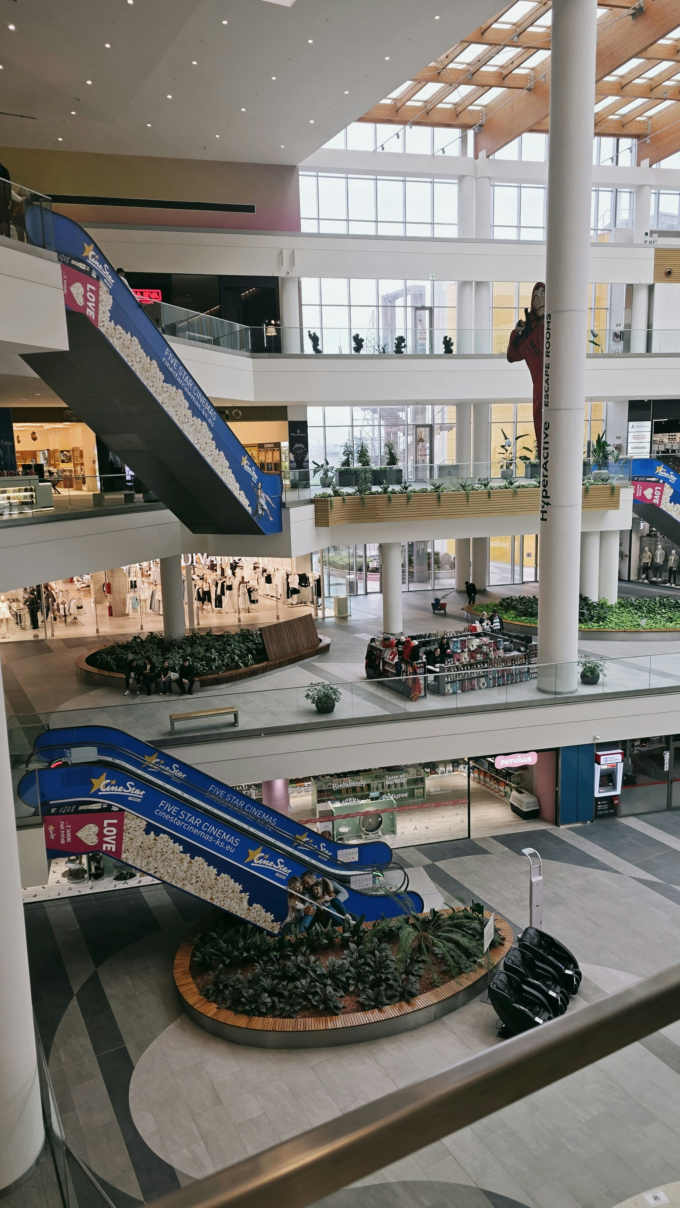 Multi-Level Atrium: Escalators, Plants, and Circular Planter
