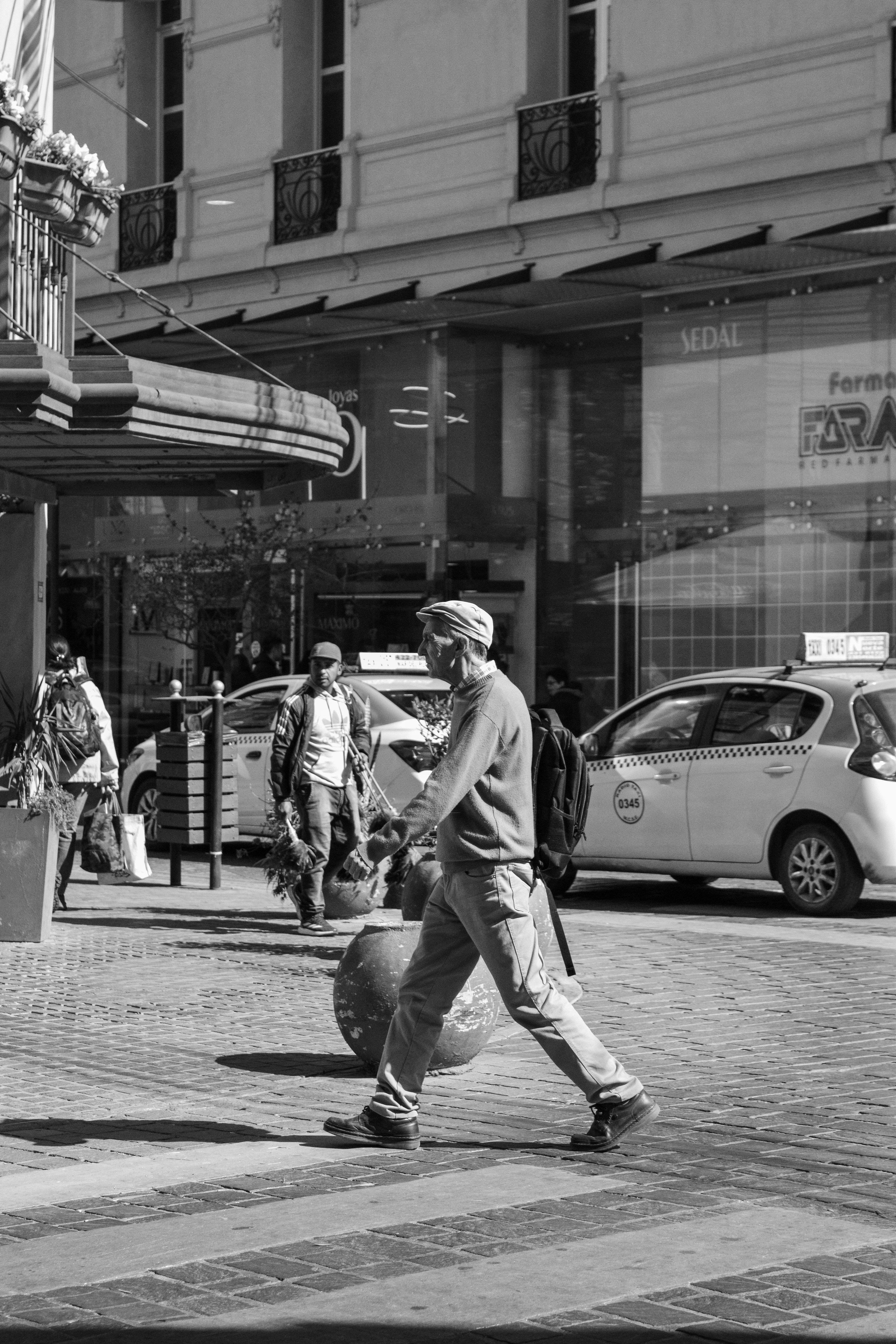 Pedestrian in motion across a cobblestone city street