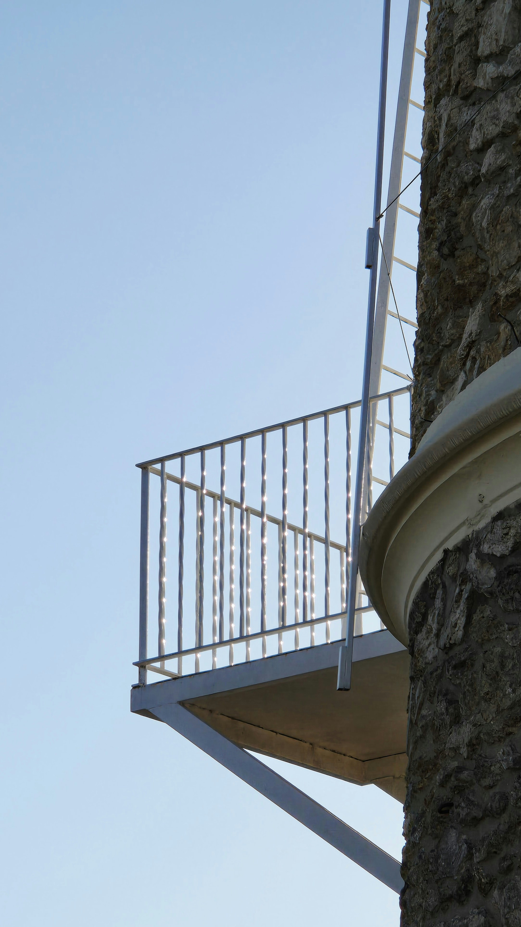 Balcony Edge and Stone Tower: A Vertical Dance with Metal Railings