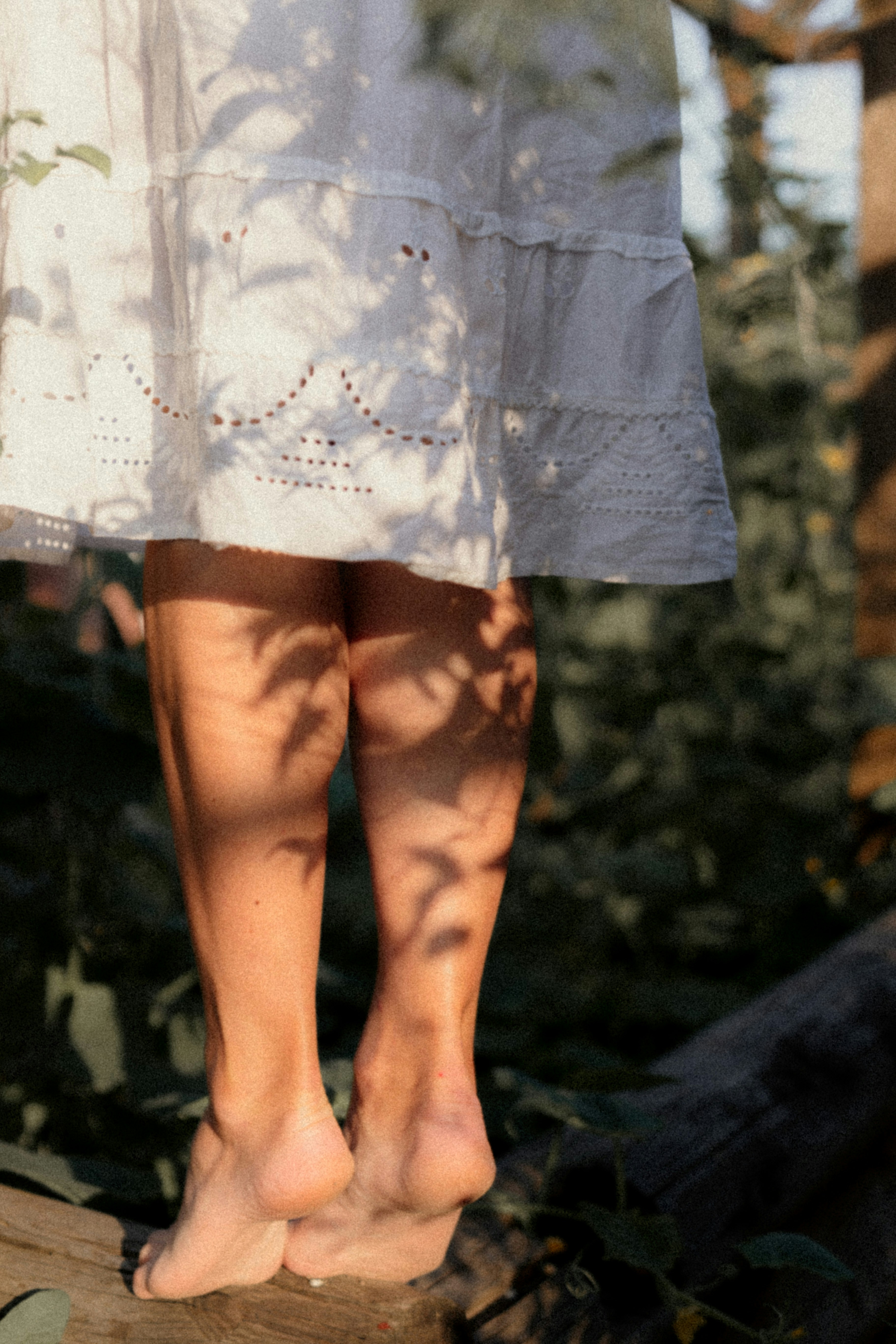 Shadowed Steps: Bare Feet Hover Over Dappled Ground