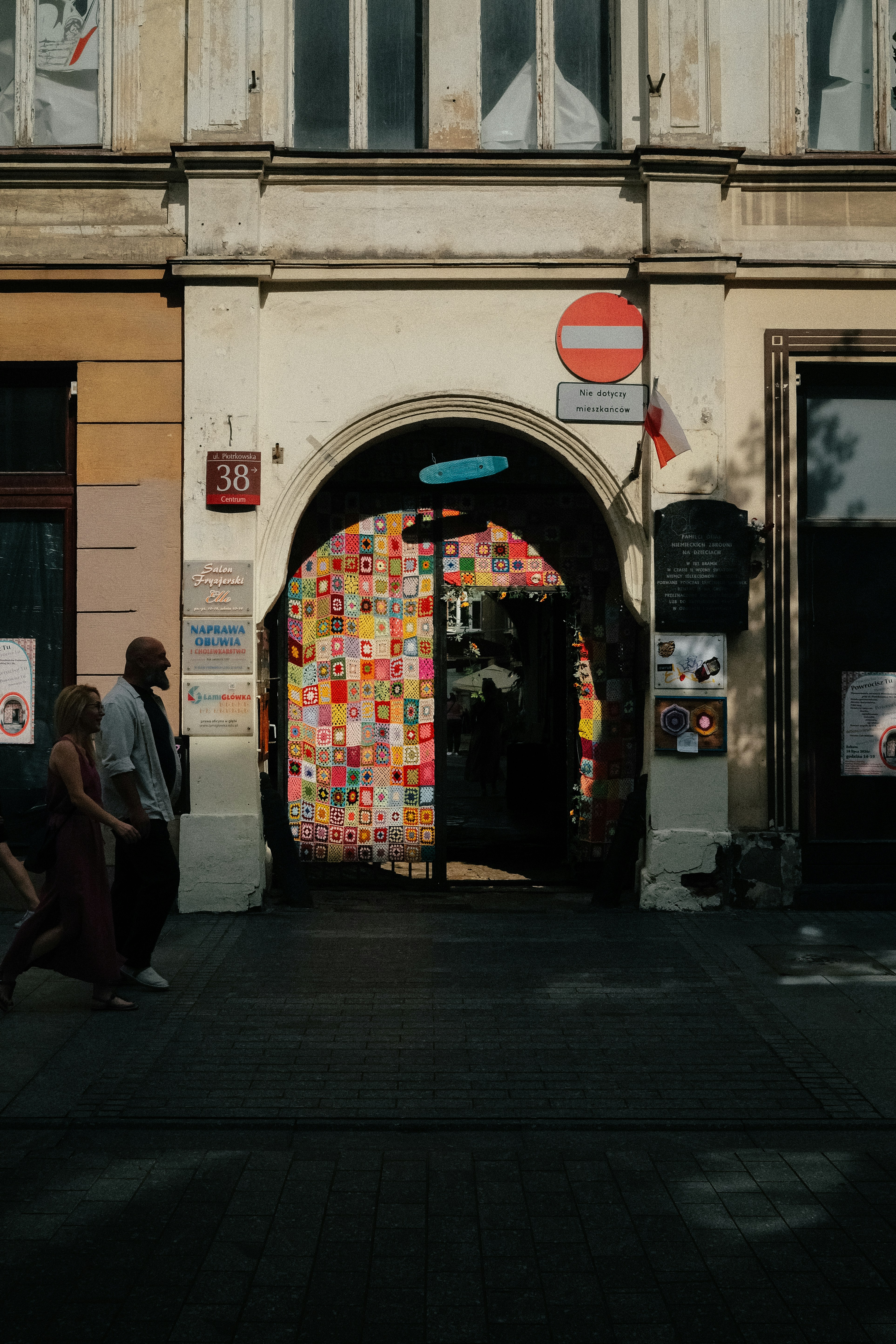 Arched Entrance Framed by Colorful Quilt Doorway in Sunlit Street