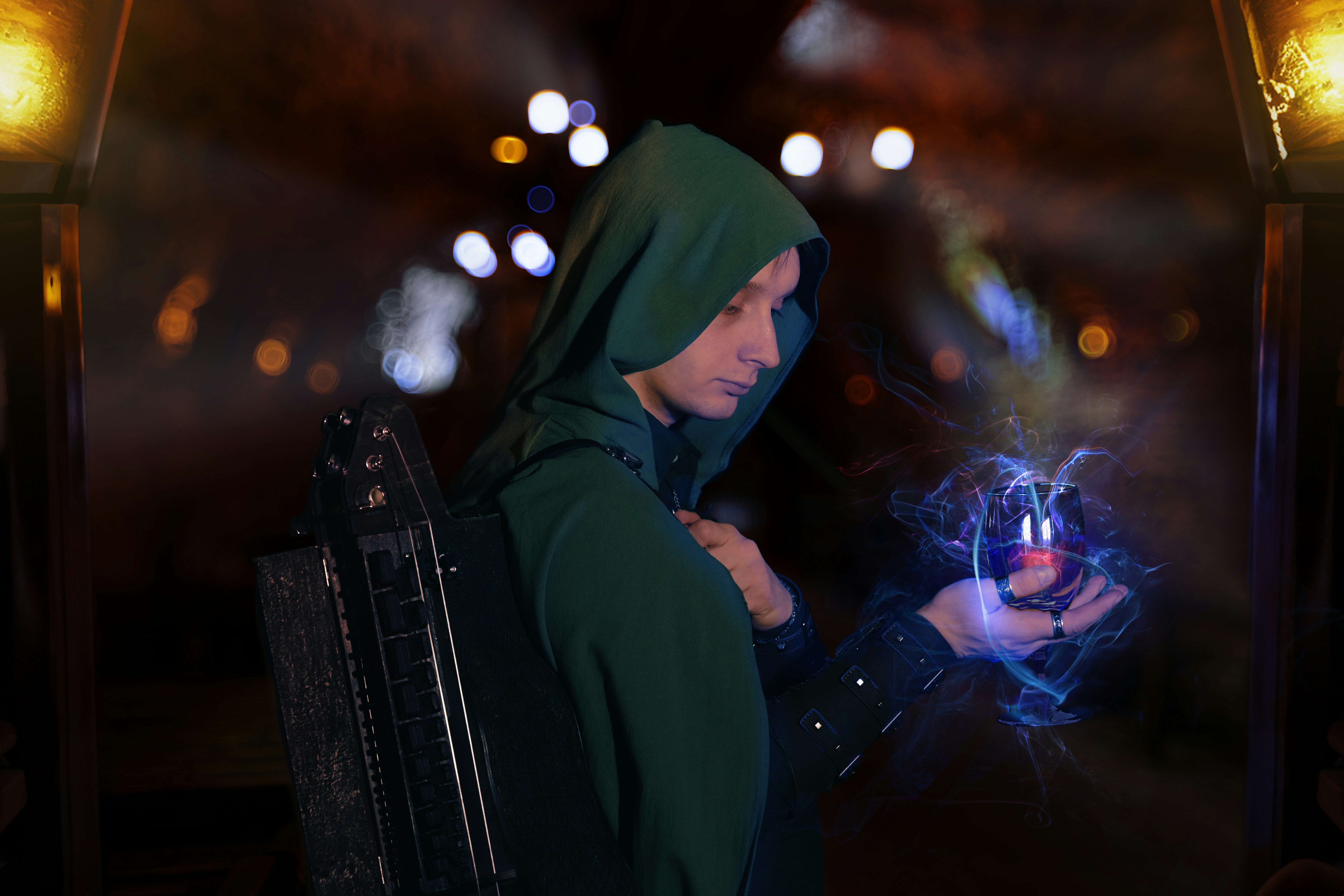 Green-hooded sorcerer conjures blue sparks in a quiet night