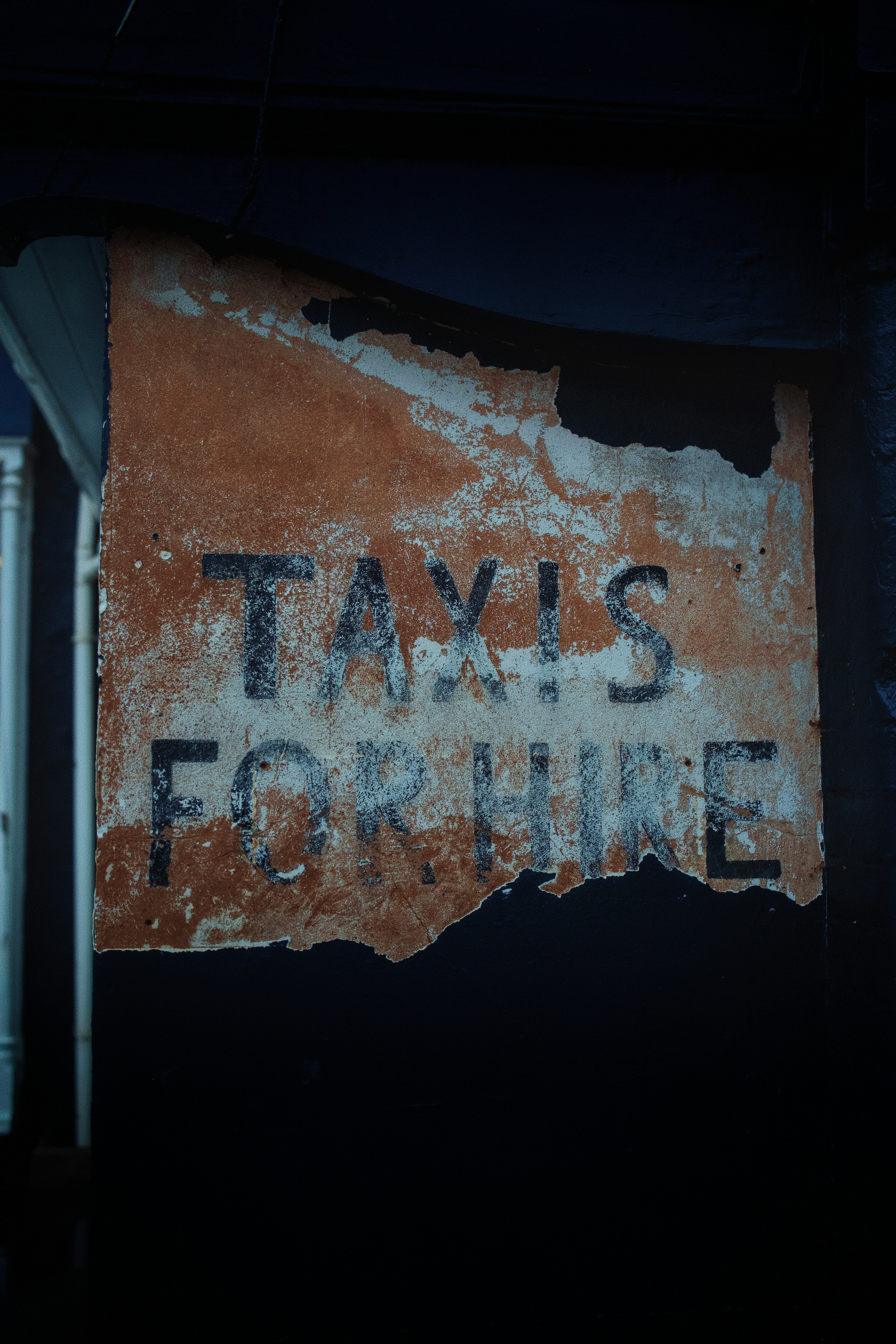 Weathered Taxi Sign in a Shadowed Corner