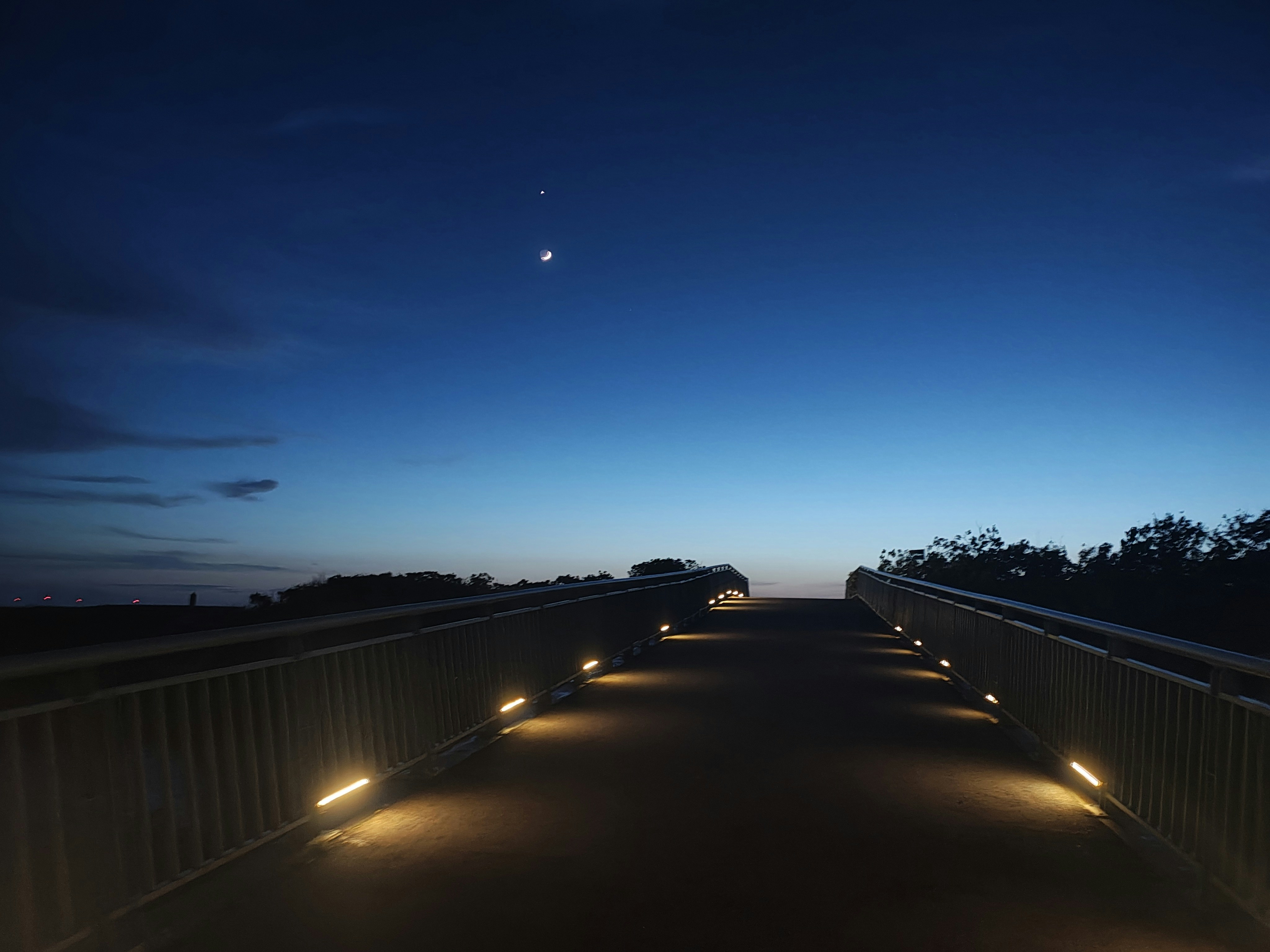 Evening Crossing: Lights on the Bridge into Dusk
