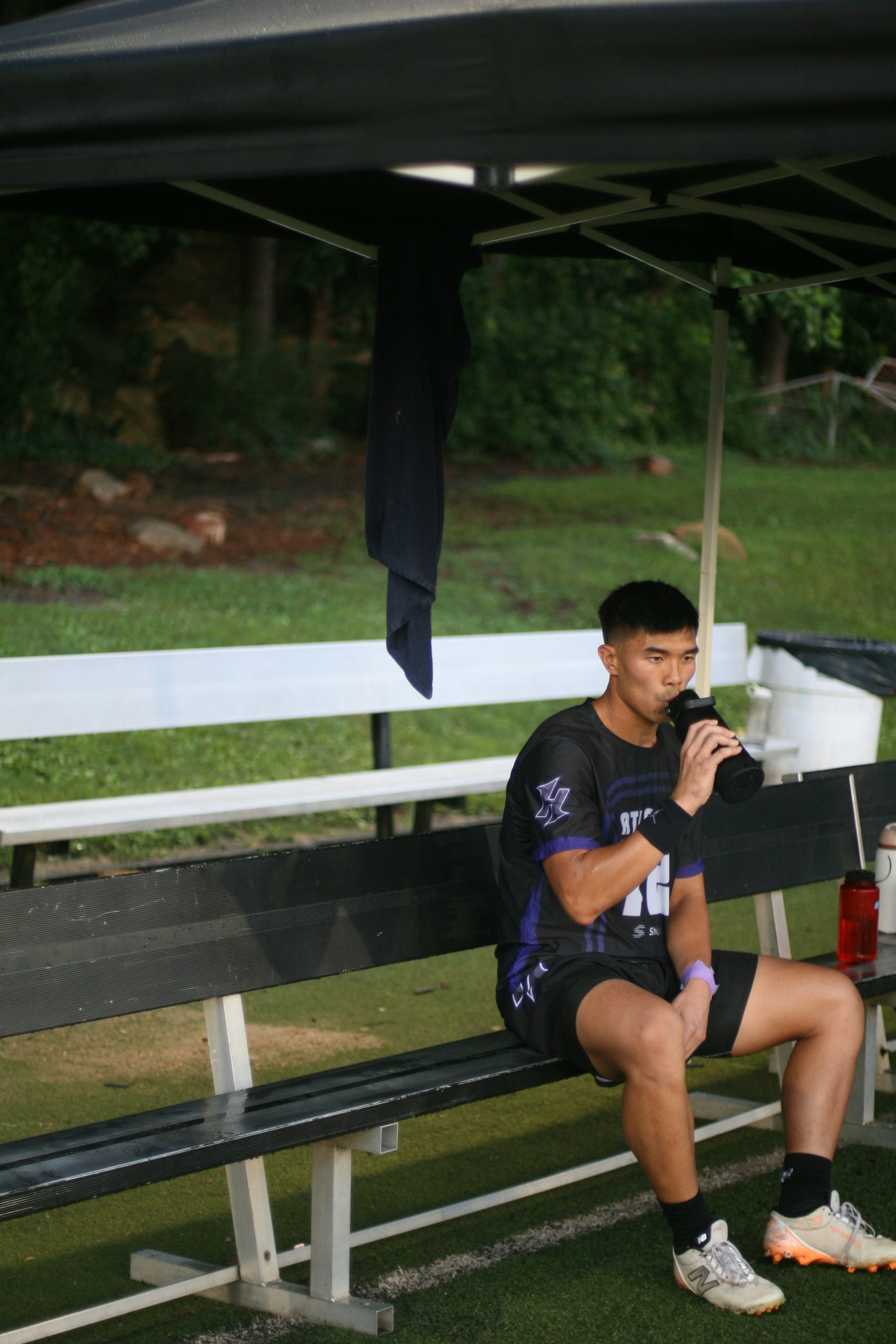Athlete in Deep Focus: Gatorade Break Under the Canopy