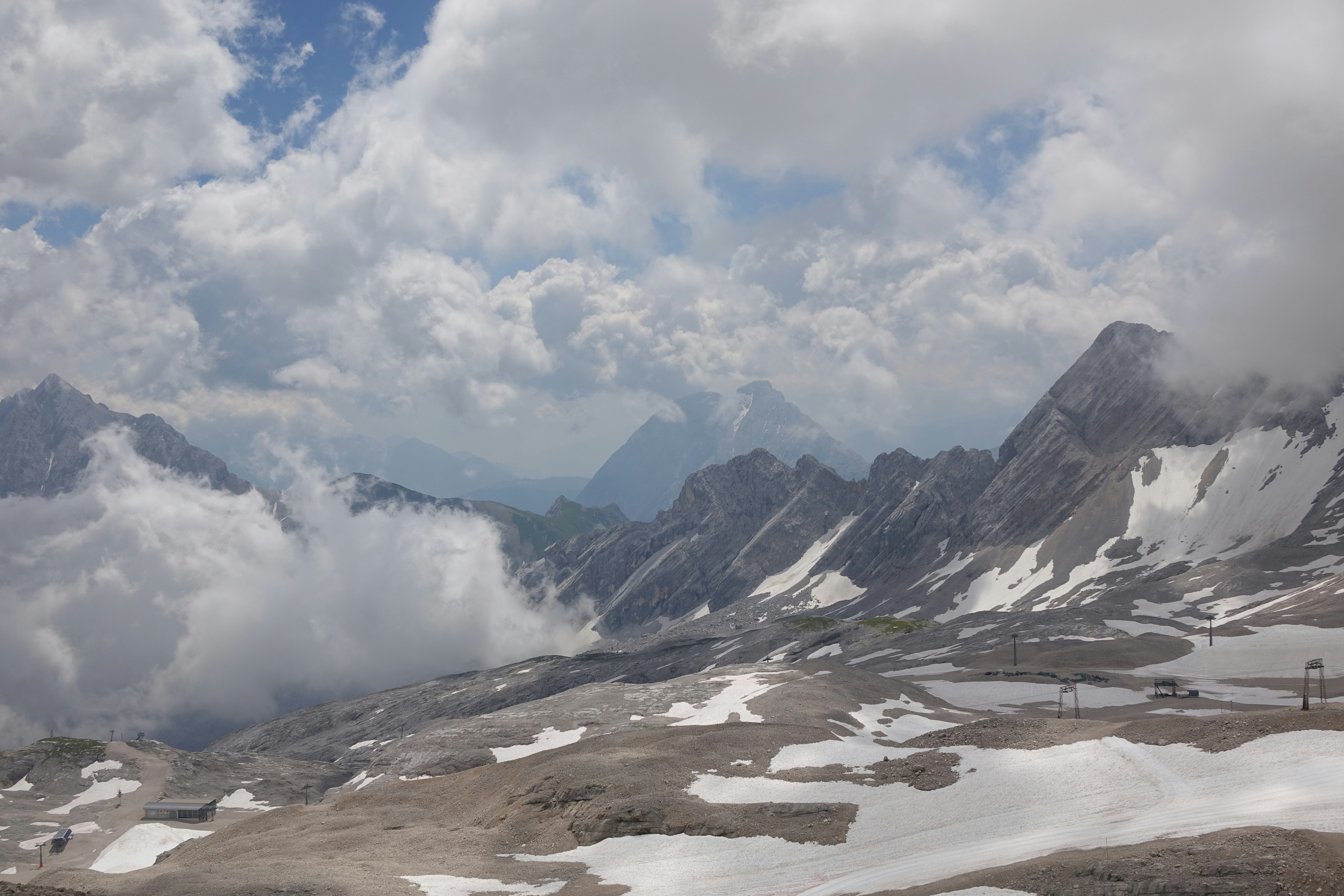 Snow-dotted ridgeline under a sculpted sky