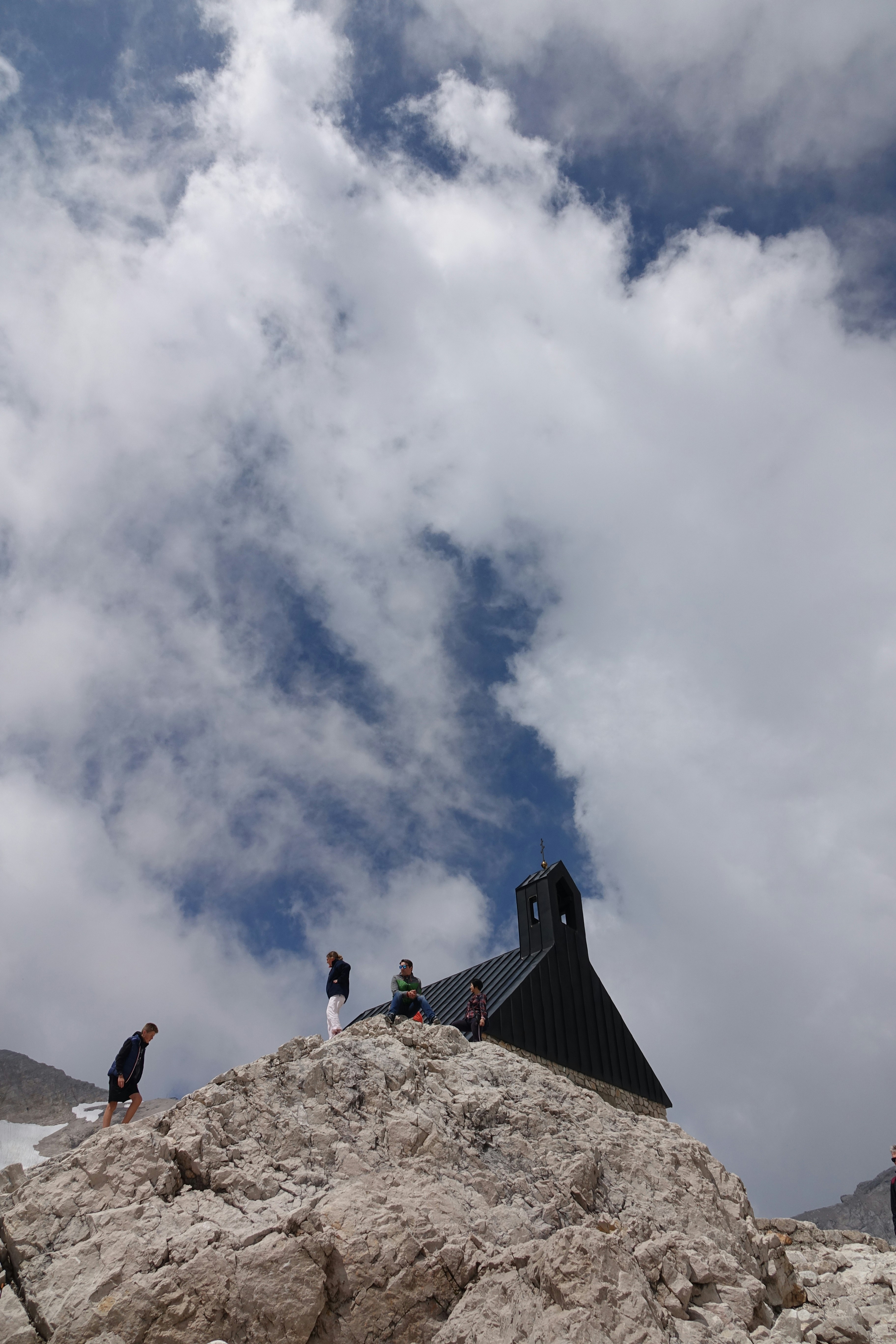 Cliffside Chapel: Climbers Beneath a Peak-roofed Shelter