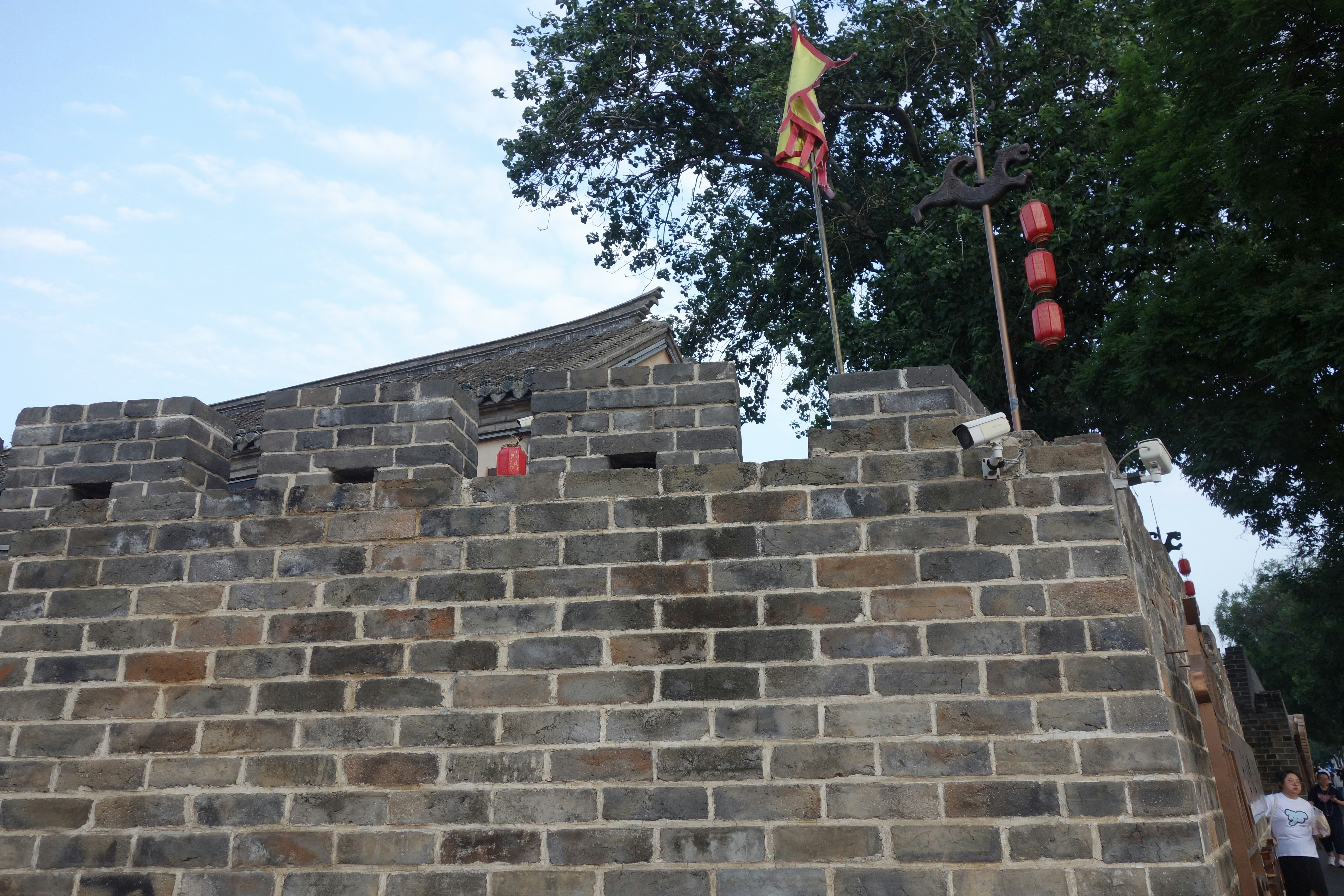 Flag atop ancient brick wall under a blue sky