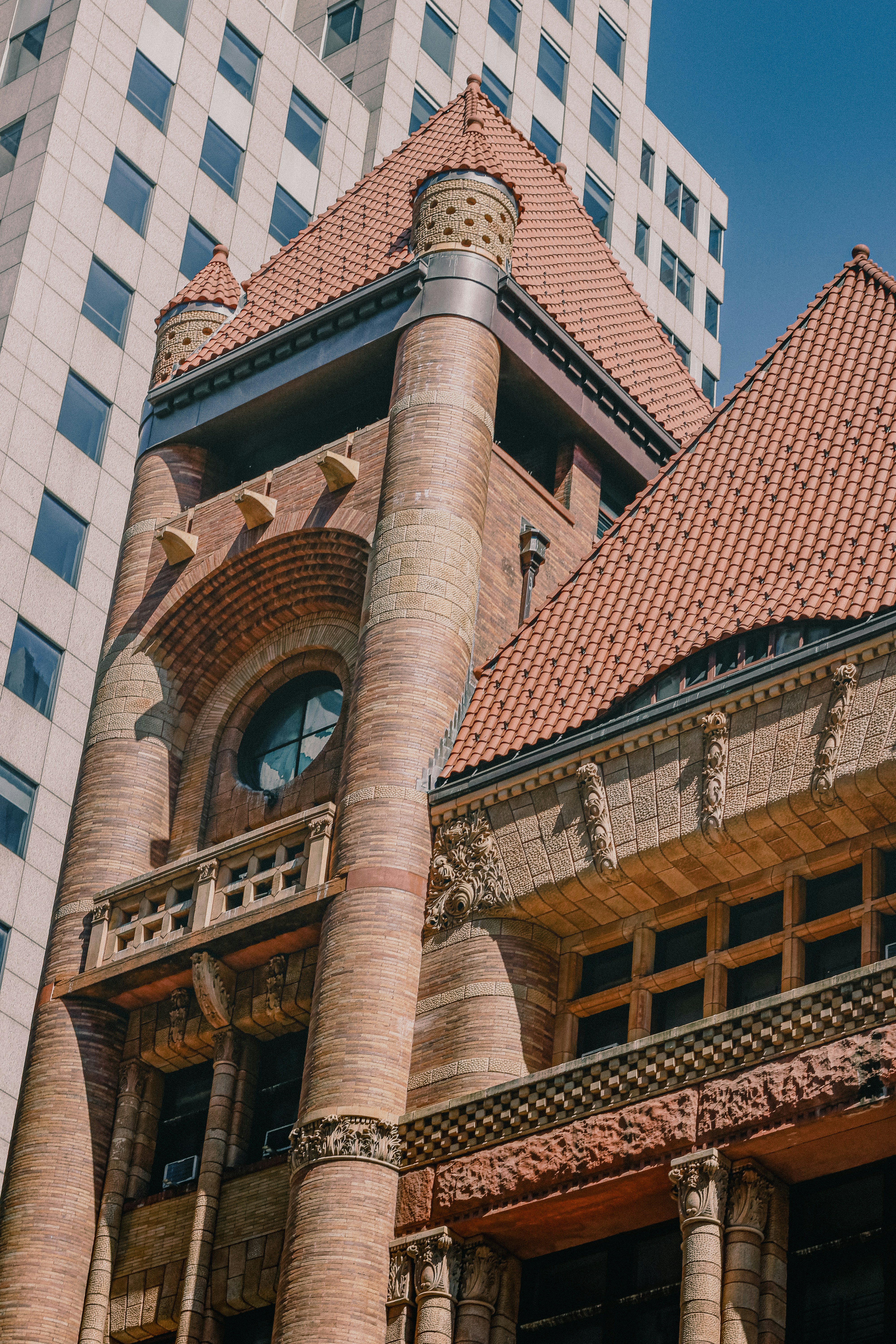 Castle-tiled meeting: a brick turreted facade against a glassy high-rise