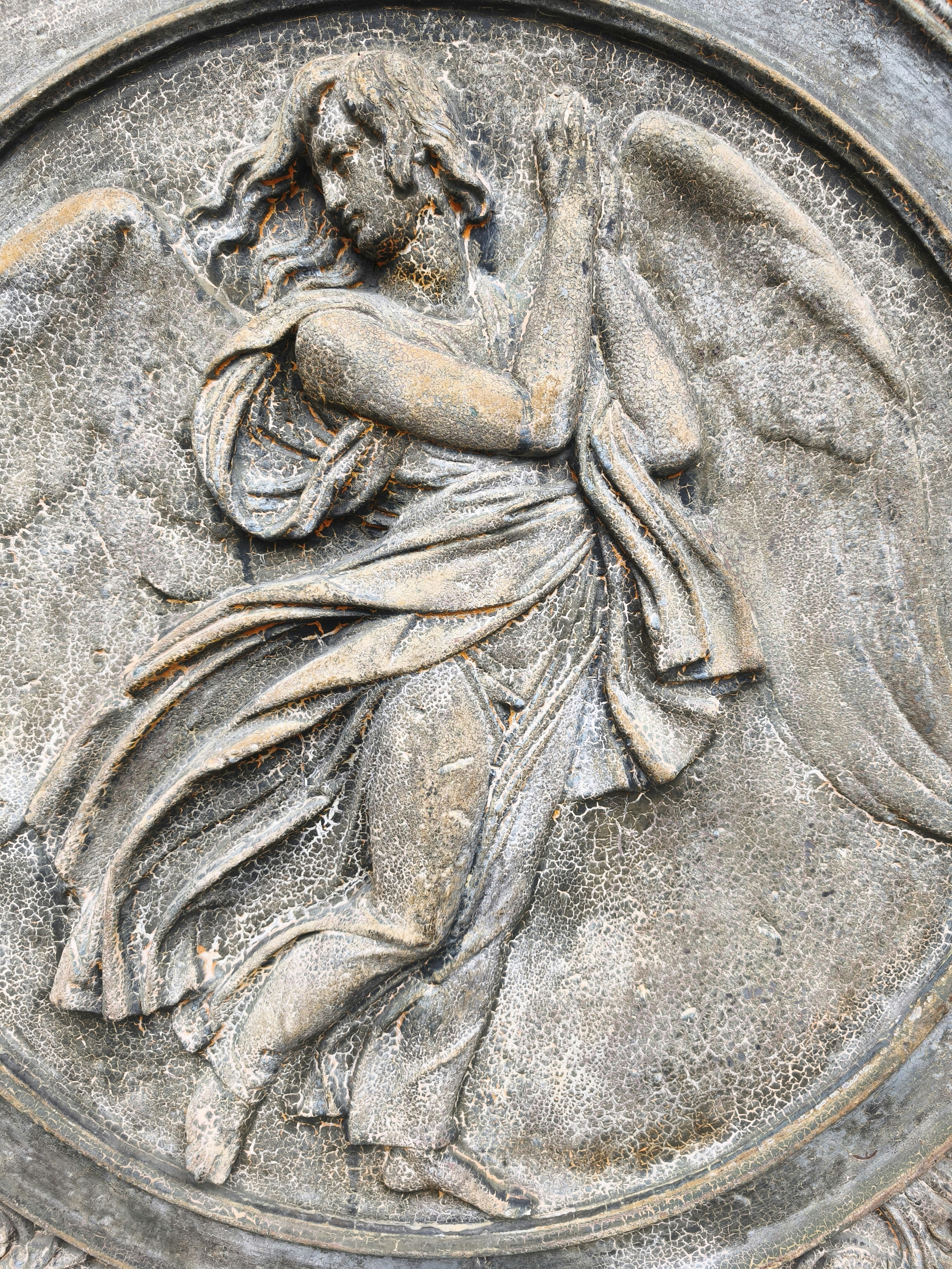 A weathered stone relief of a winged figure in flowing robes