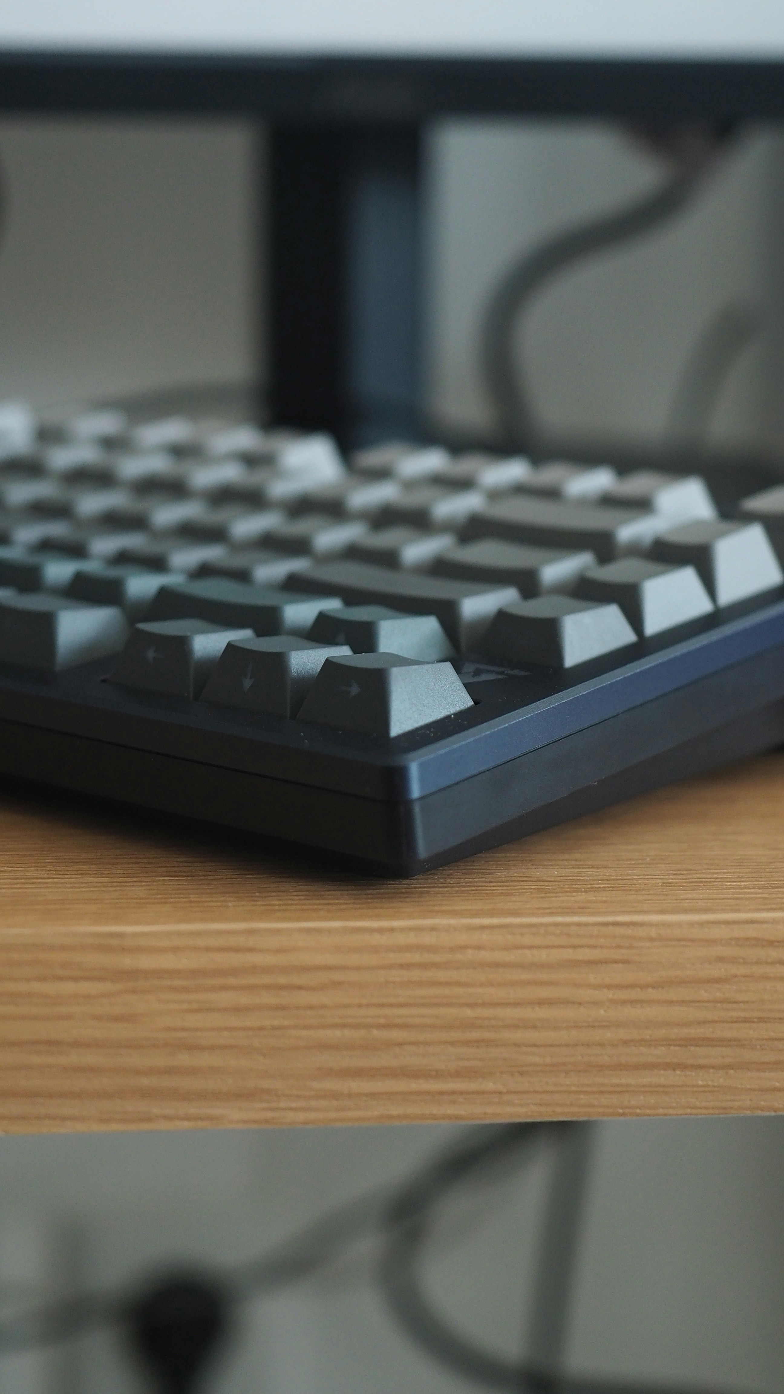 Low-angle keyboard close-up resting on a wooden desk