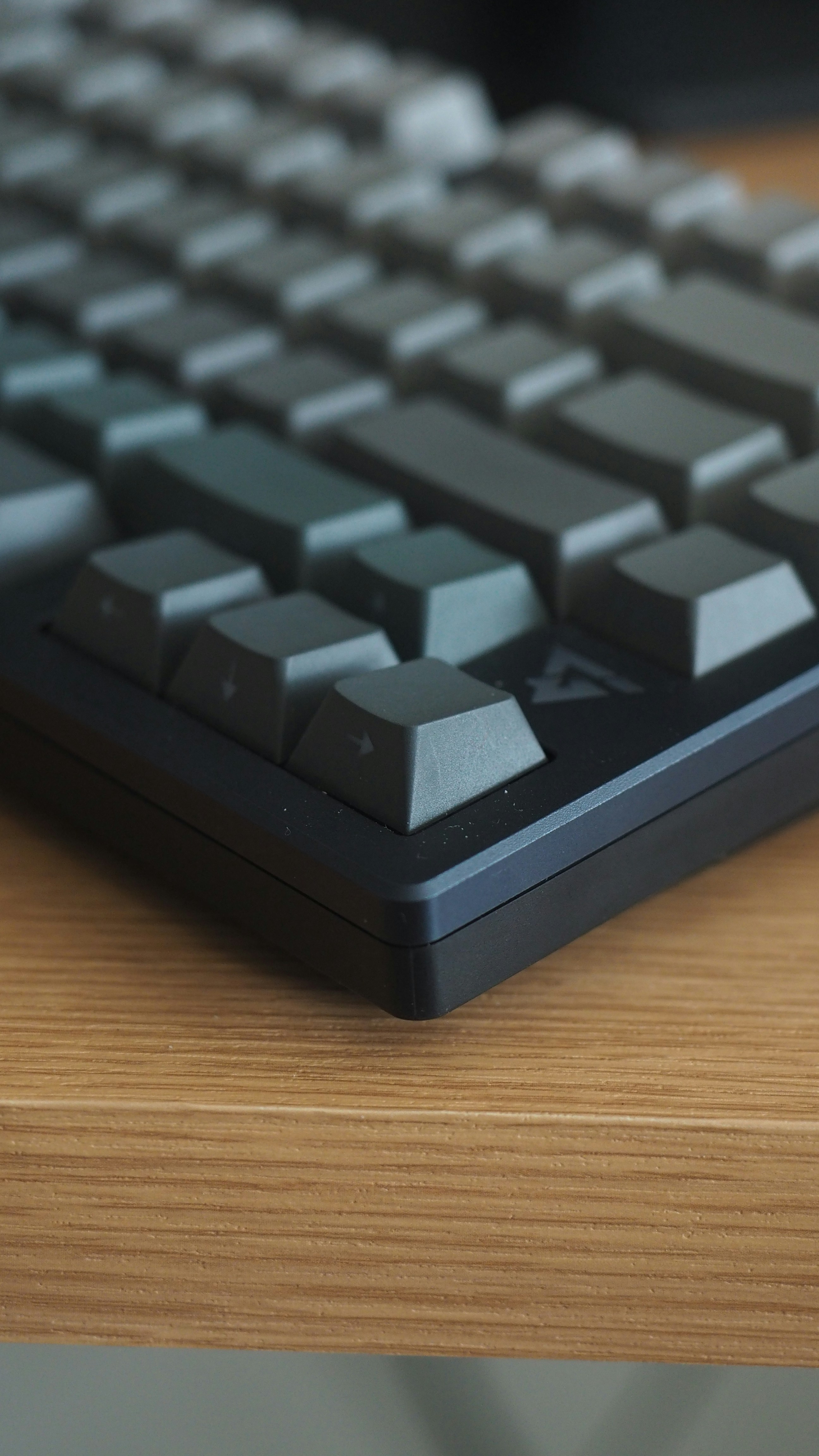 Low-angle close-up of a mechanical keyboard resting on a wooden desk