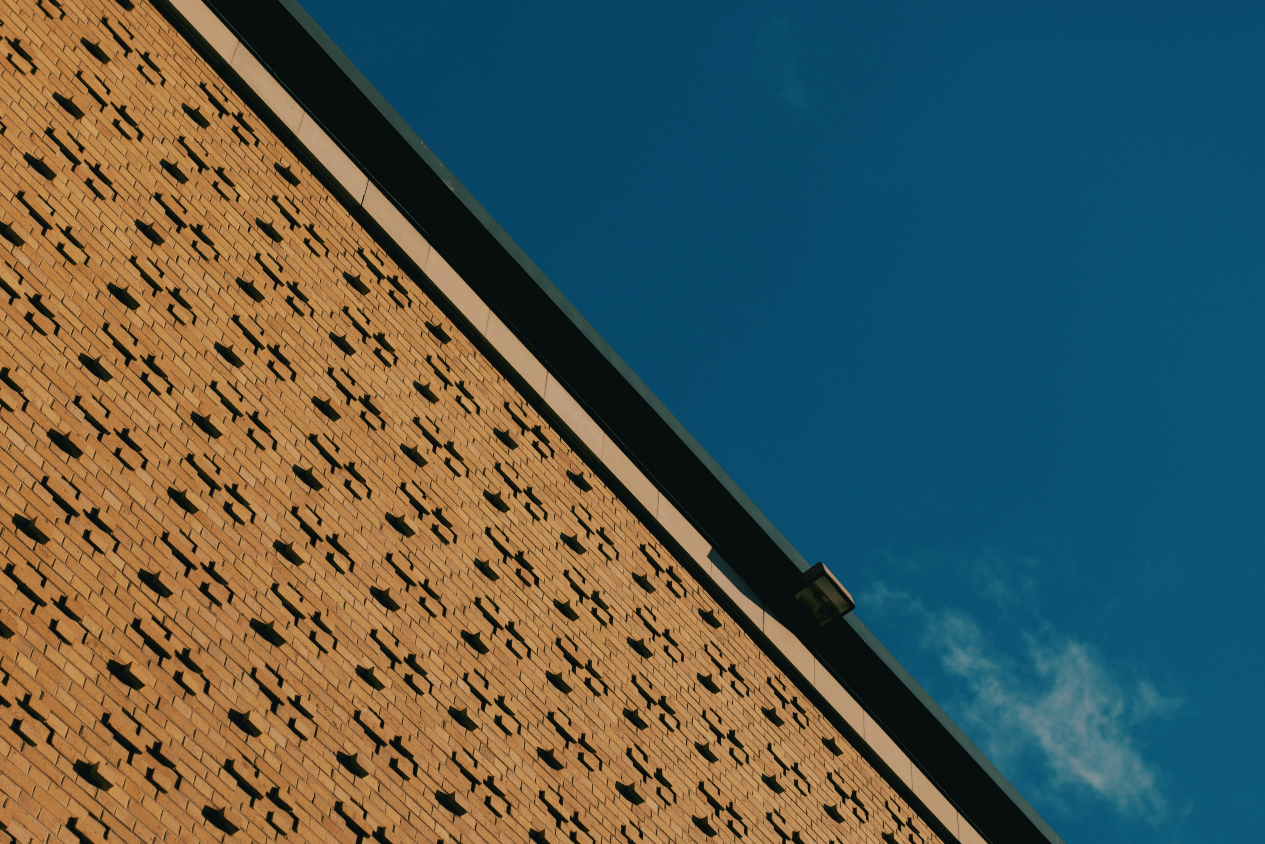 Edge of Brick: A Sliver of Sky Above a Diagonal Facade