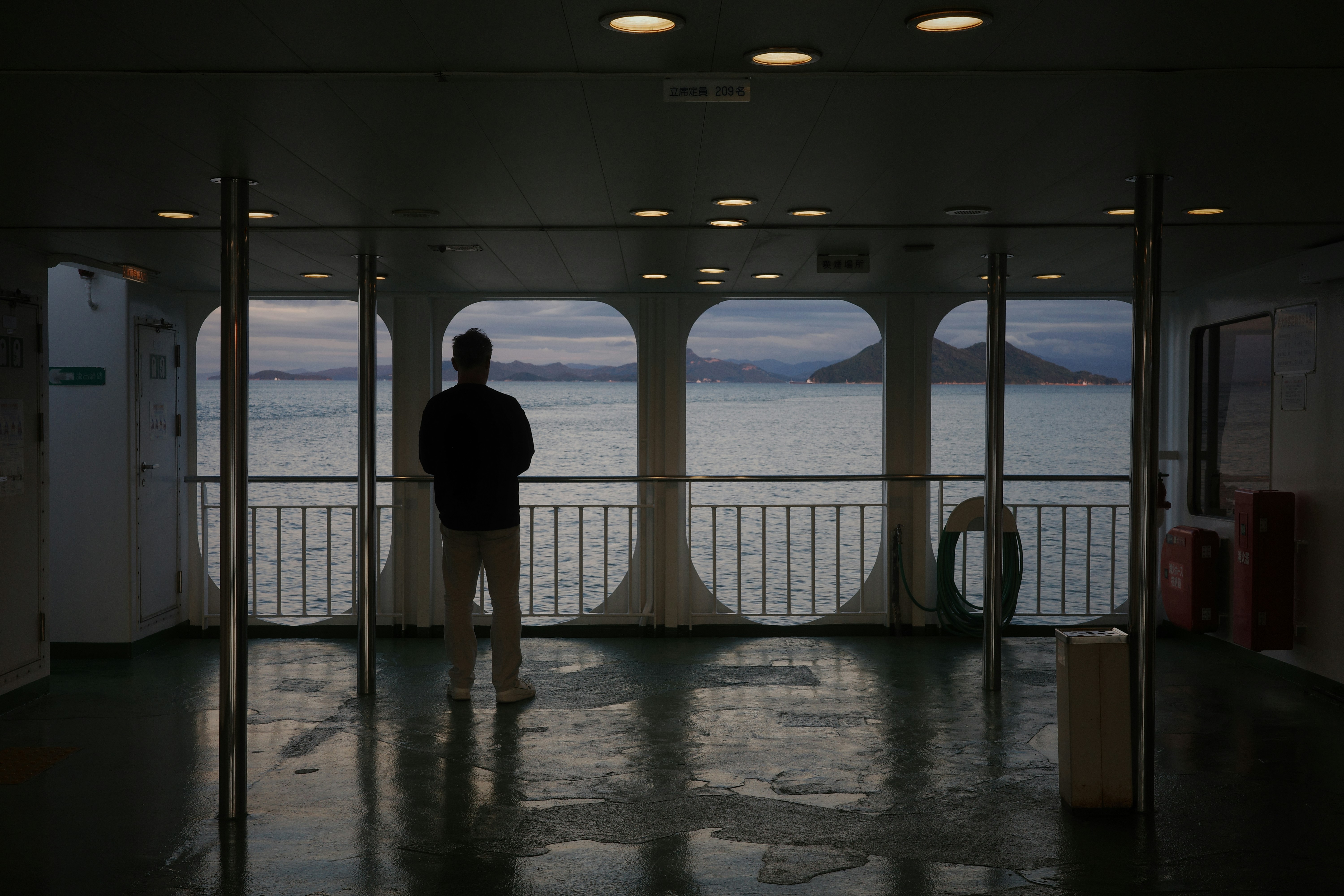 Silhouette at the Ferry Deck: A Solo Moment Over Quiet Waters