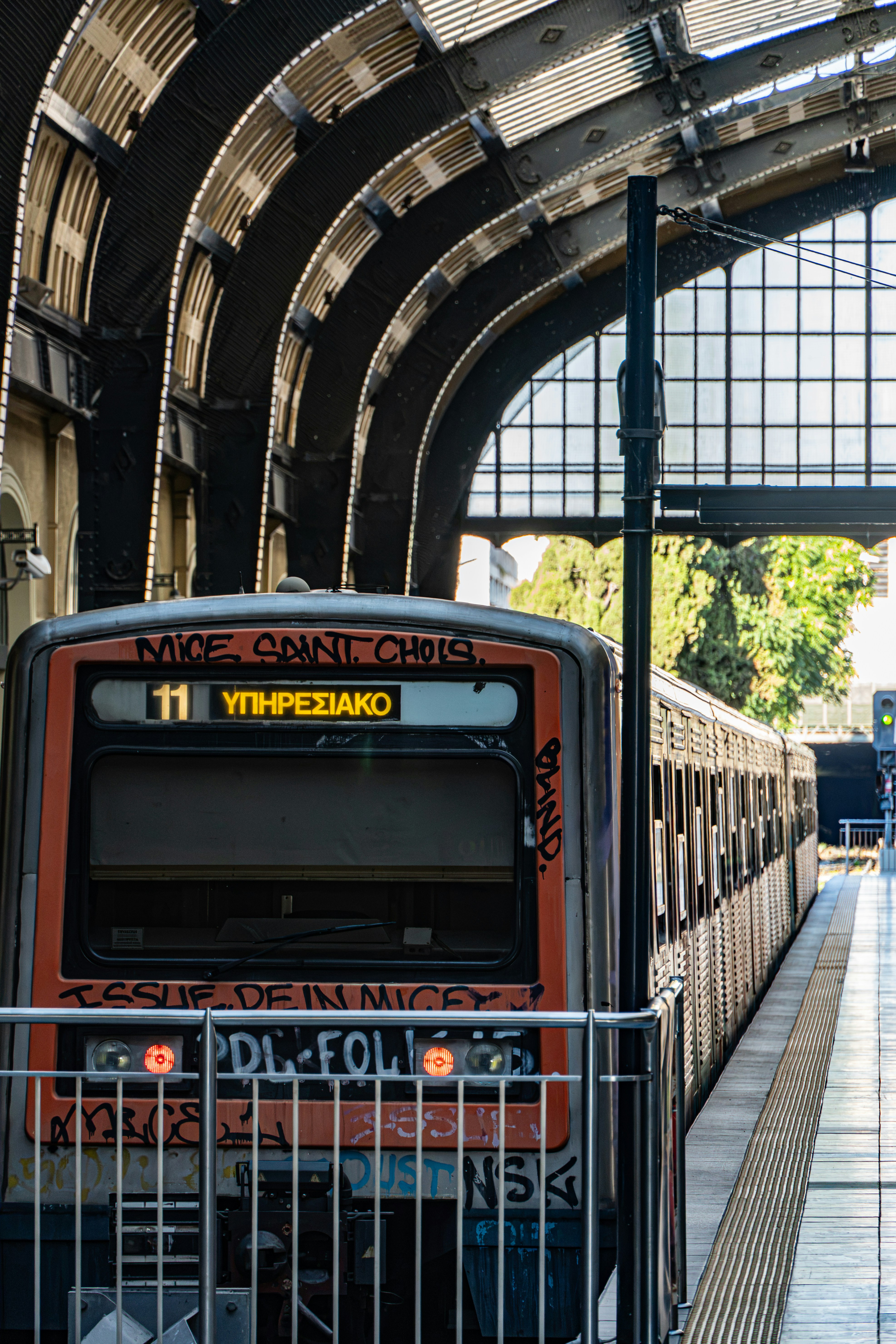 Graffitied Commuter: A Train Weathers the Station Canopy