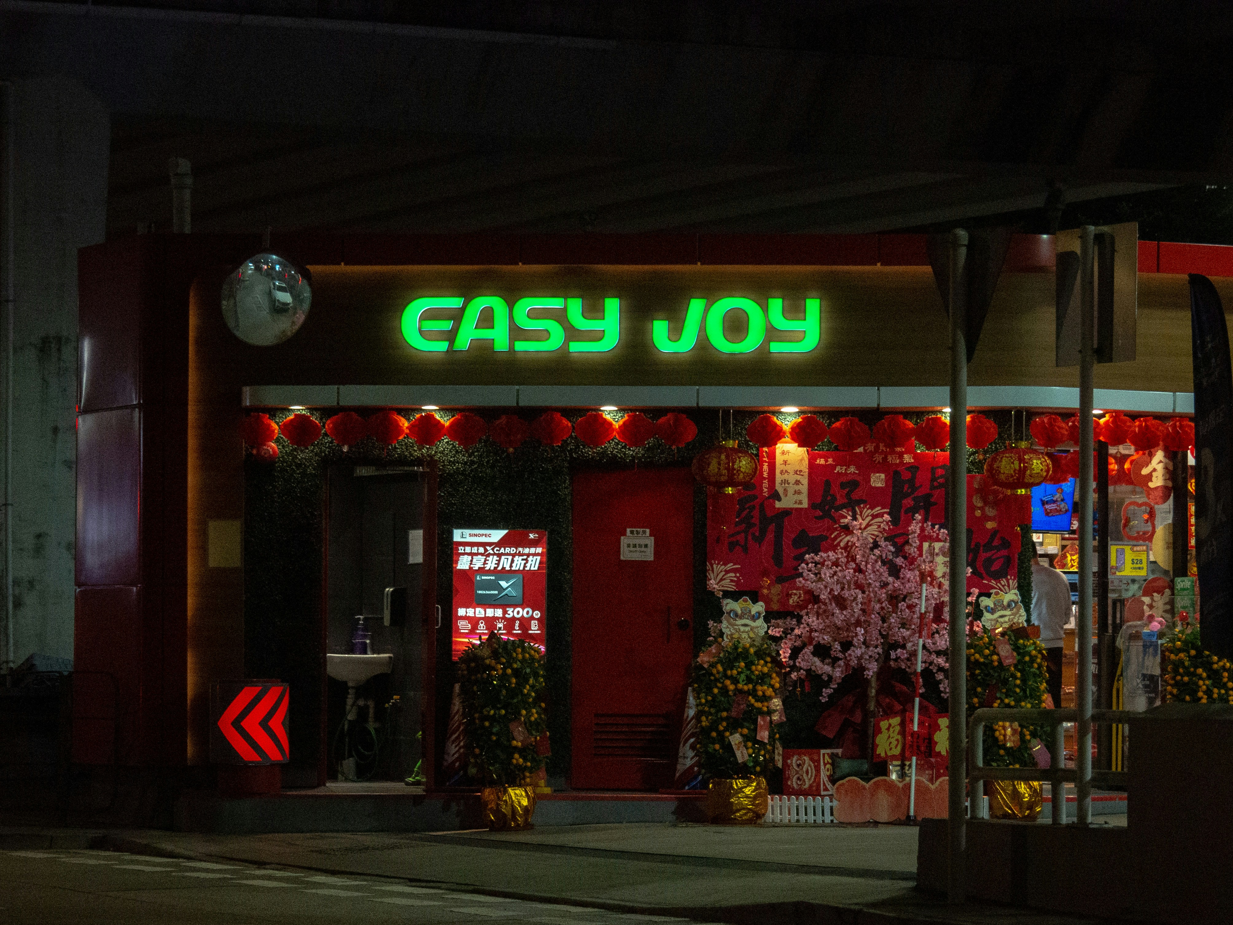 Neon Green Sign Above a Festive Red storefront