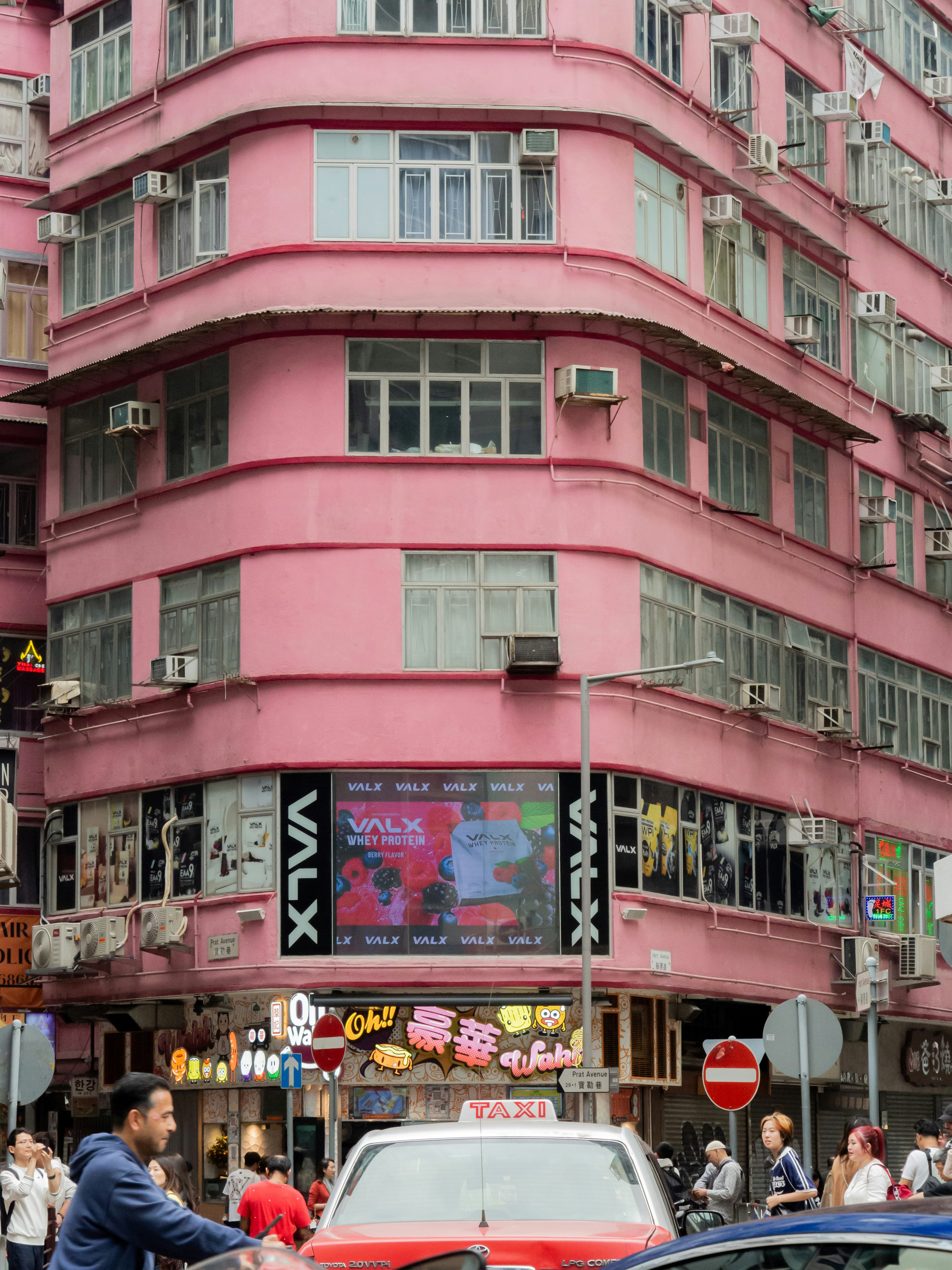 Pink Curves in the City: A Ground-Level View of a Bustling Urban Corner