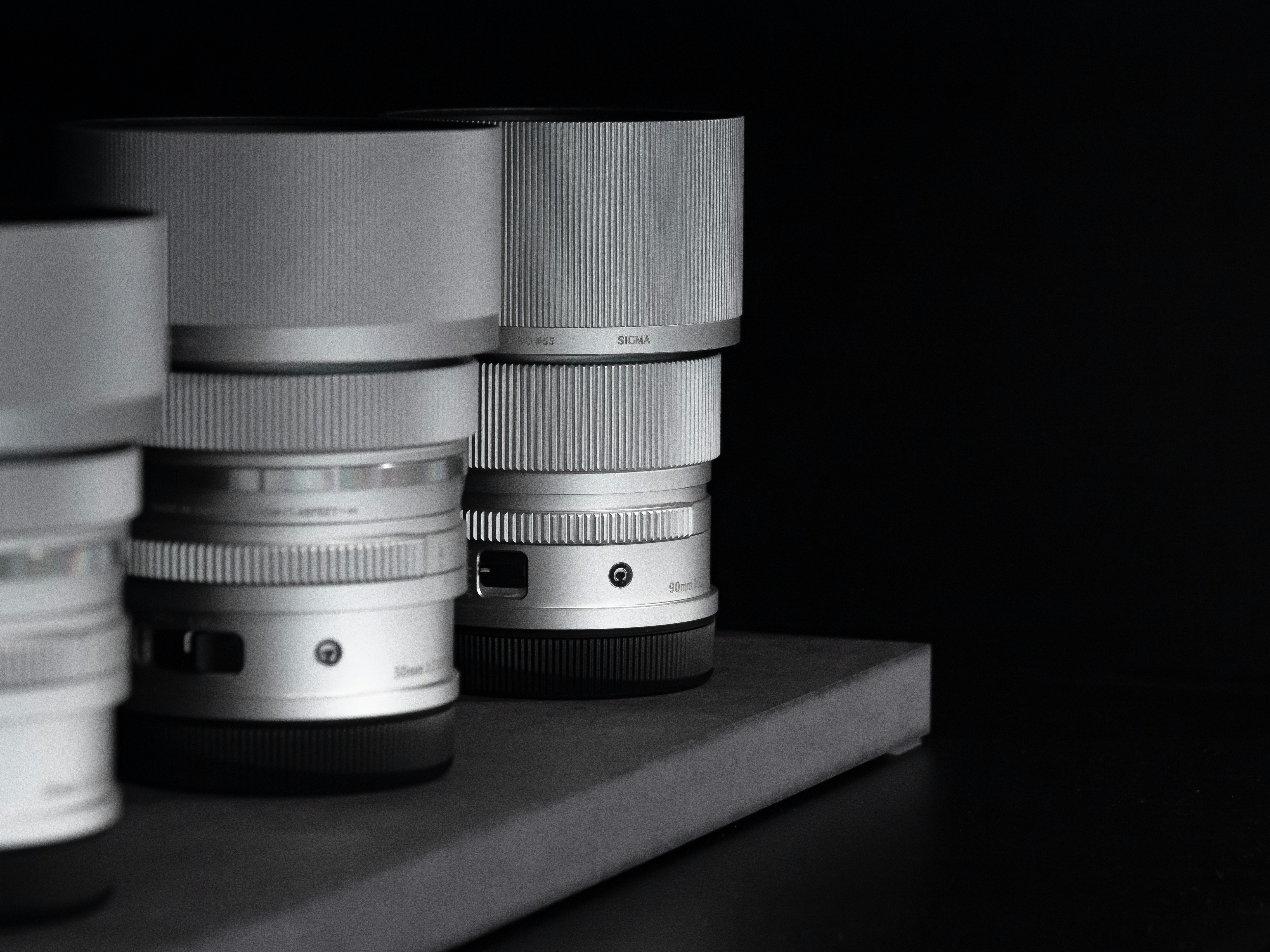Row of Vintage Lens Cylinders on a Dark Platform